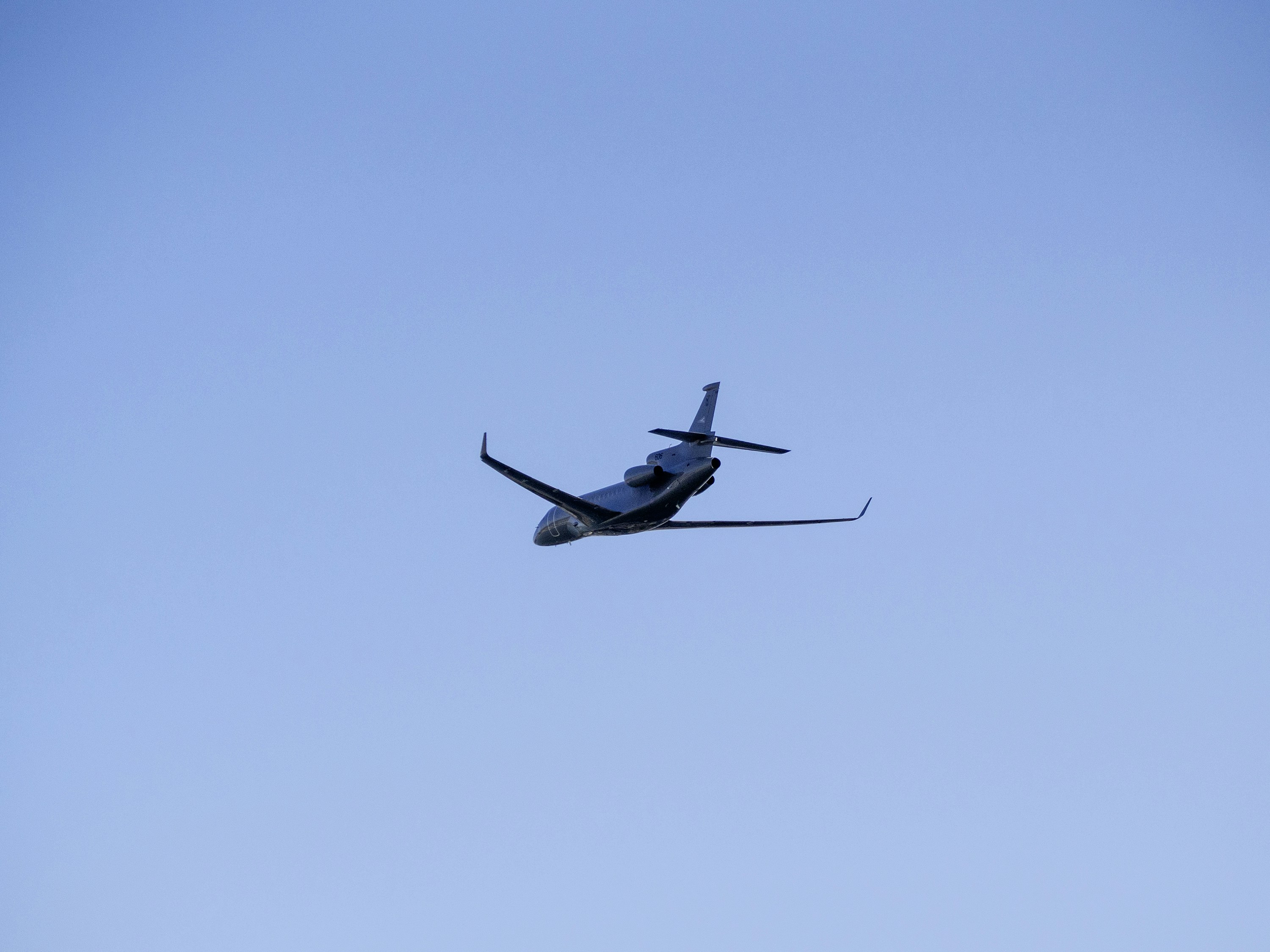 Soaring Silence: A Jet Traces the Sky in Clean Blue