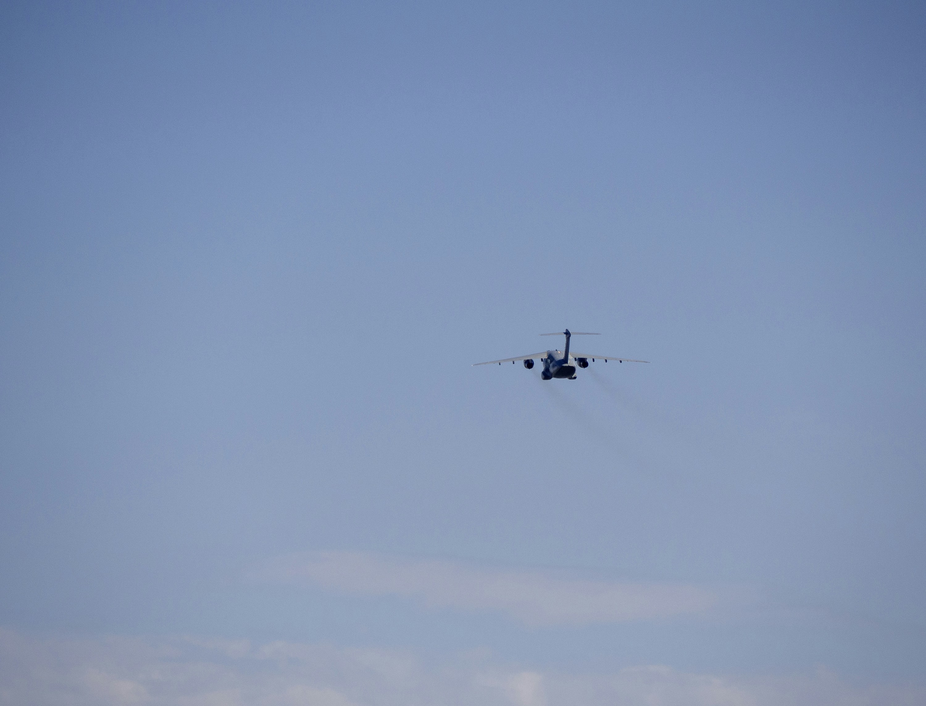 Mid-Cloud Approach: Military Jet in Quiet Skies