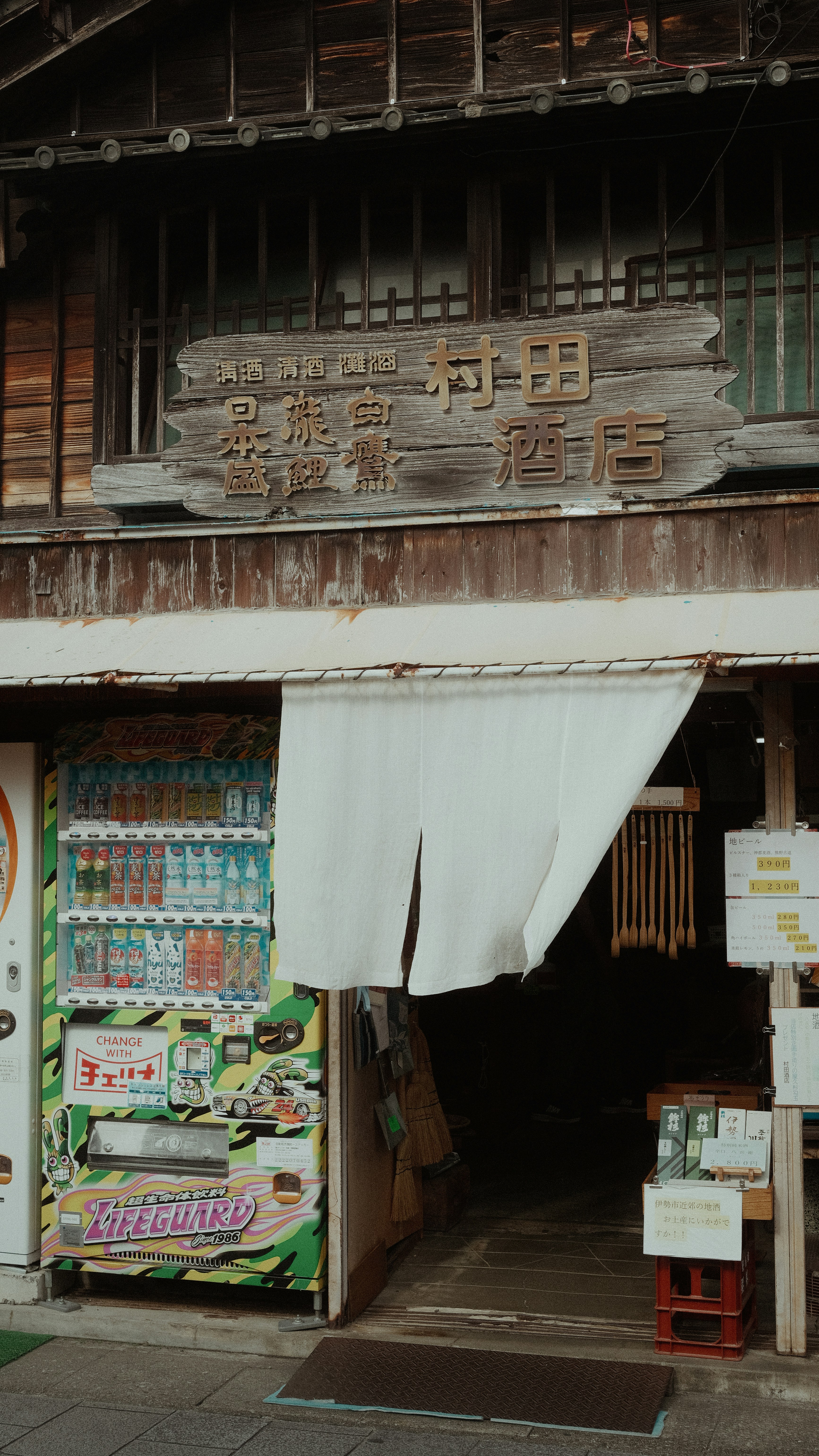 Weathered wooden signage over a tucked-away doorway in a traditional shopfront
