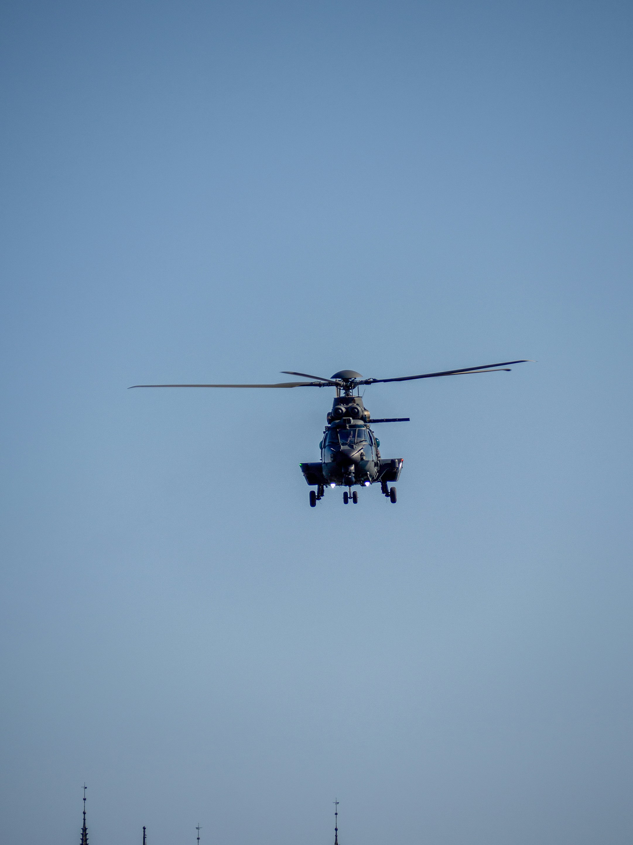 Midair Sentinel: A helicopter hovering against a clear sky