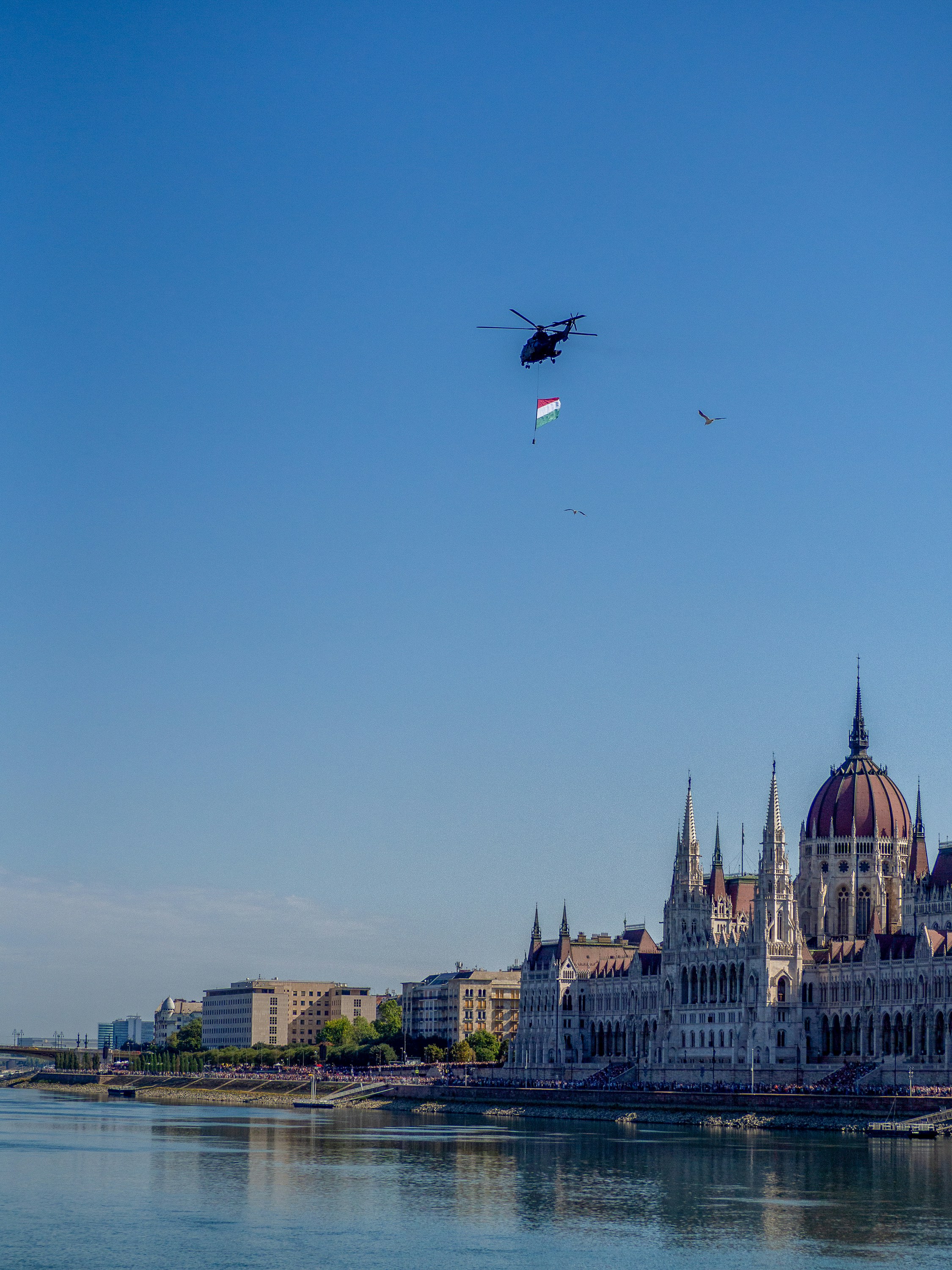 Aerial Ceremonial over the Danube: Helicopter Hauling a Flag Above Budapest