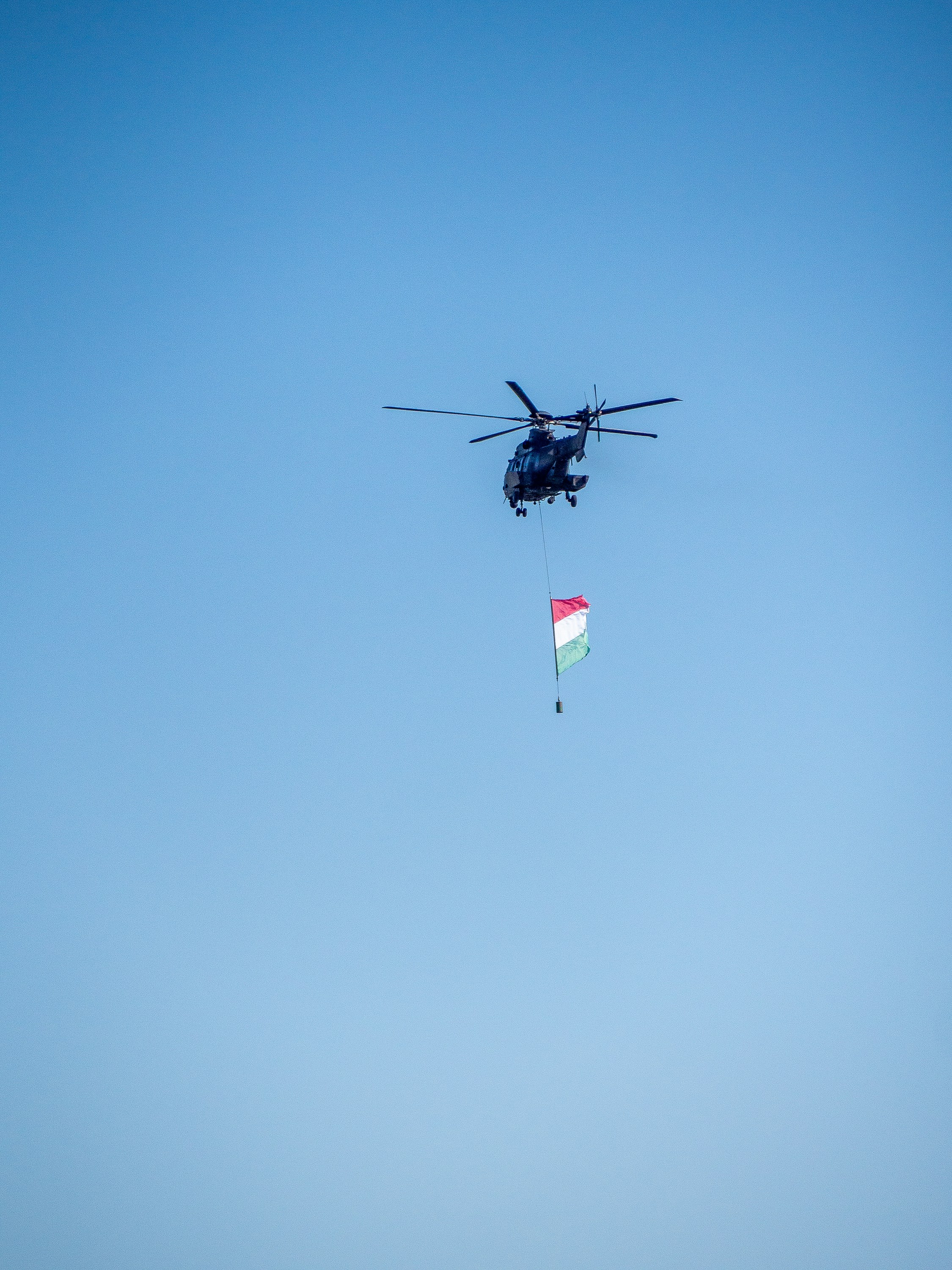 Aerial Shuttle: Helix Hoist over a Pale Blue Sky