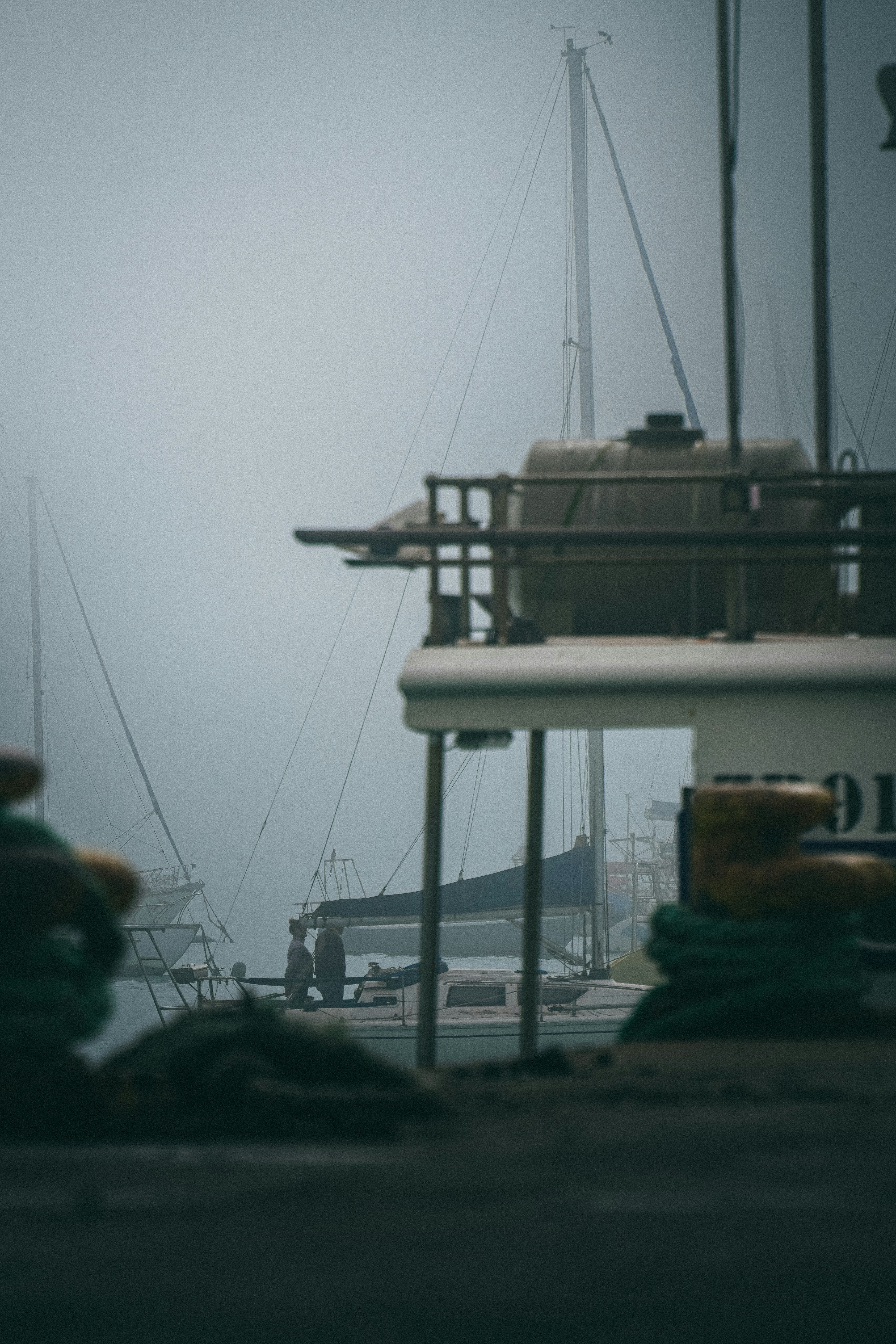 Harbor Ghosts: Boats Recede into Fog on a Quiet Dock