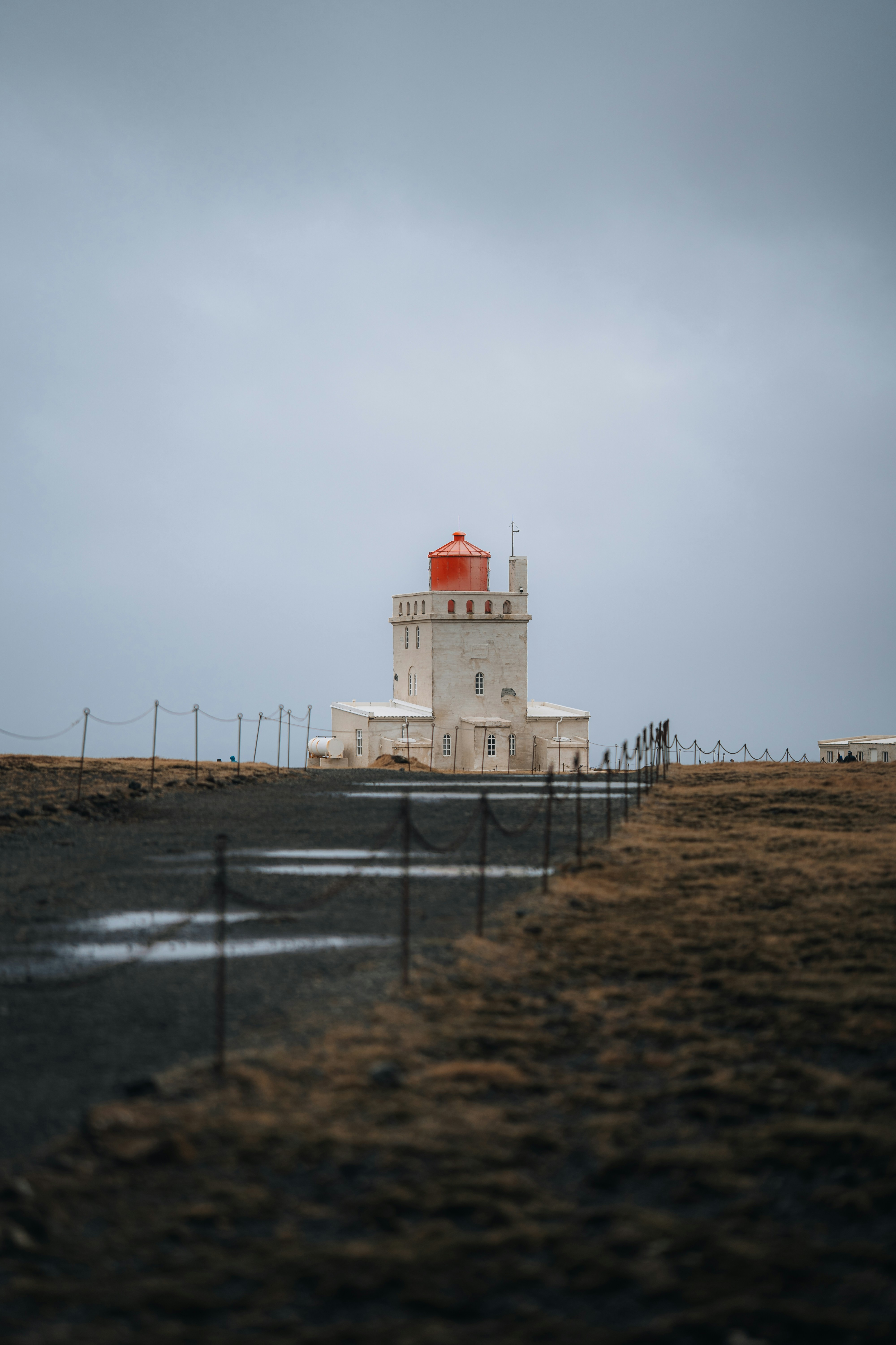 Lighthouse at the Edge: Red Cap on a Windy Plain