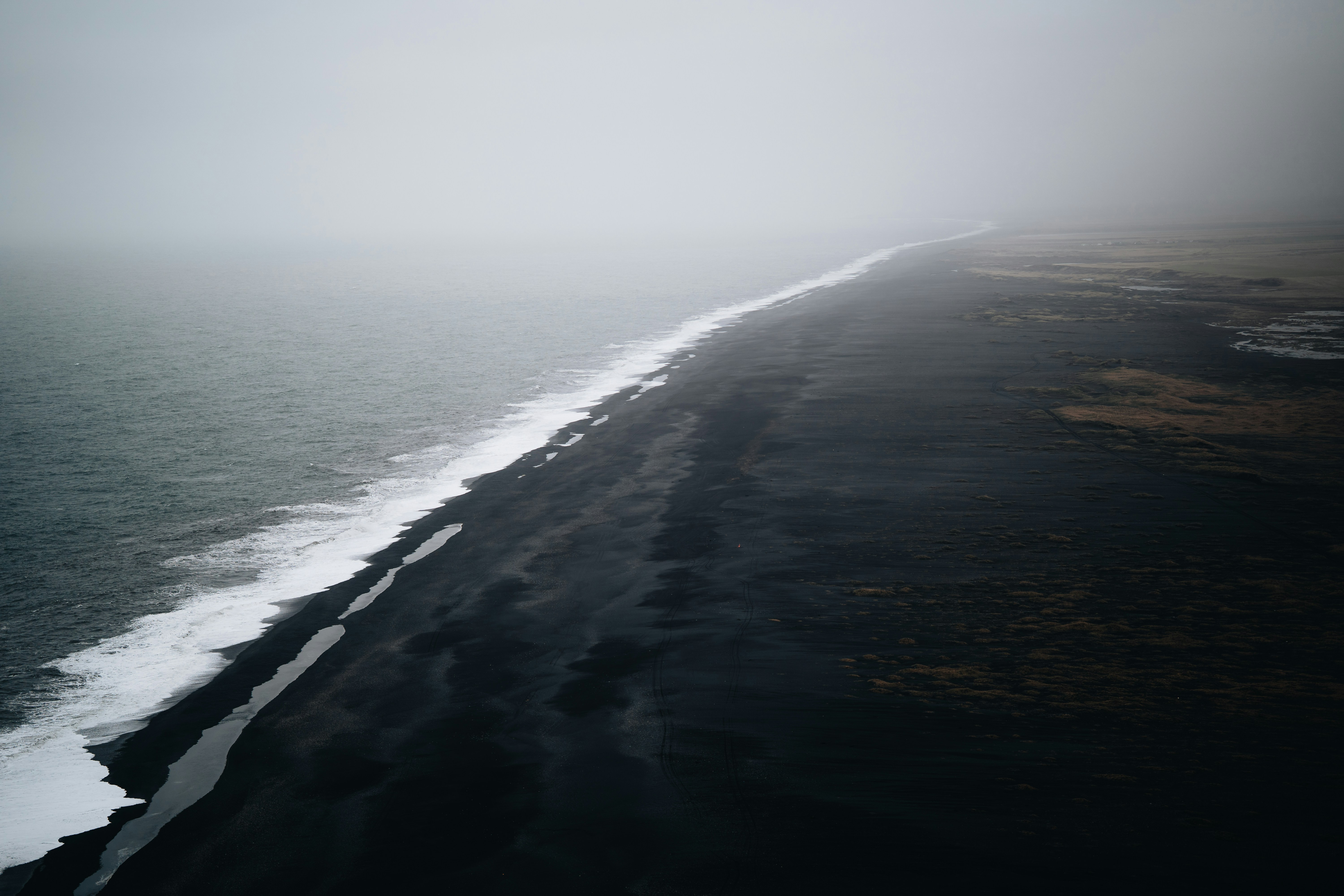 Coastal Vignette: A Misty Black Sand Shore Receding into Fog