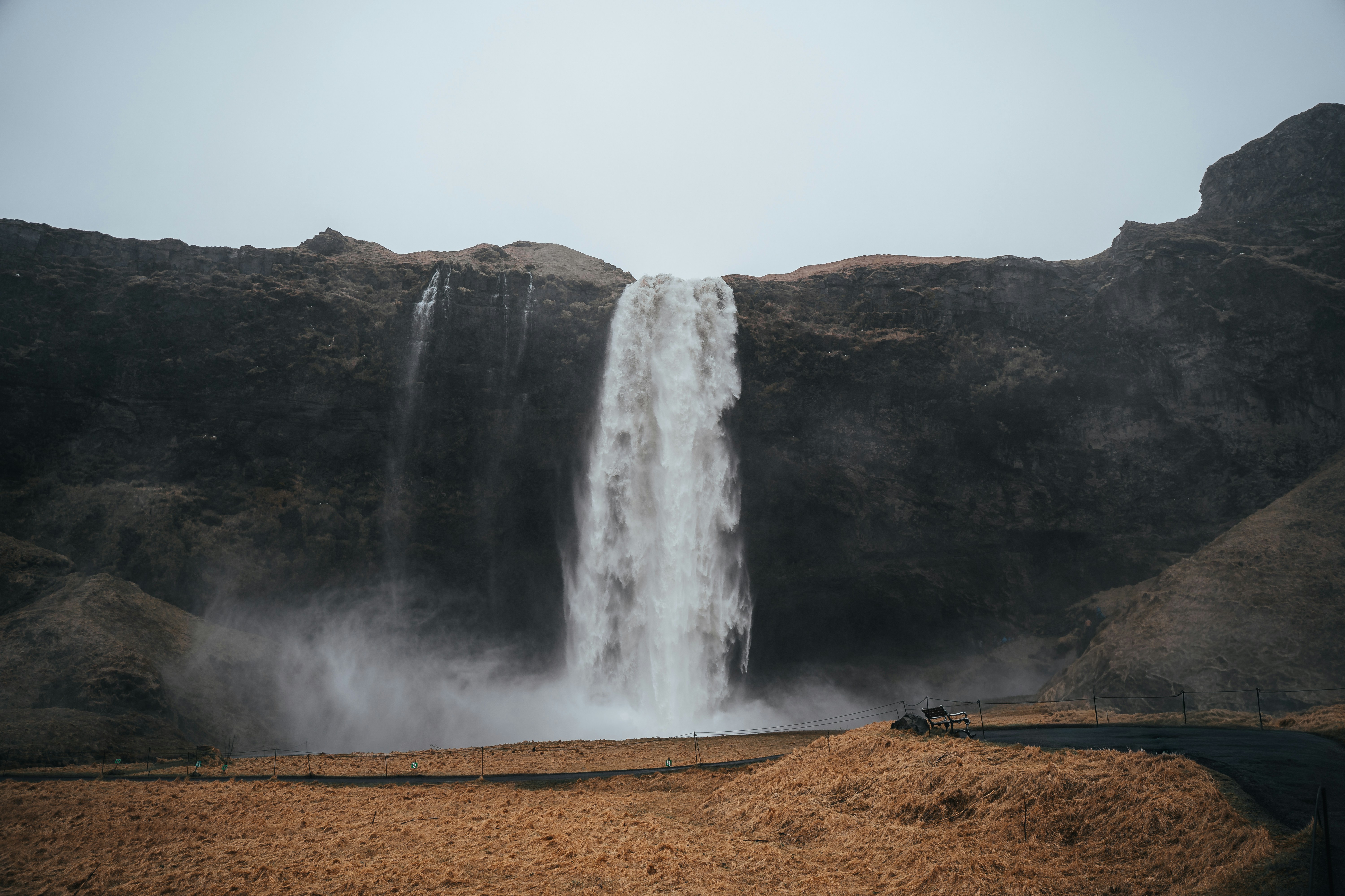 Cascade at the Edge: A Veil of Water Over Dark Cliffs