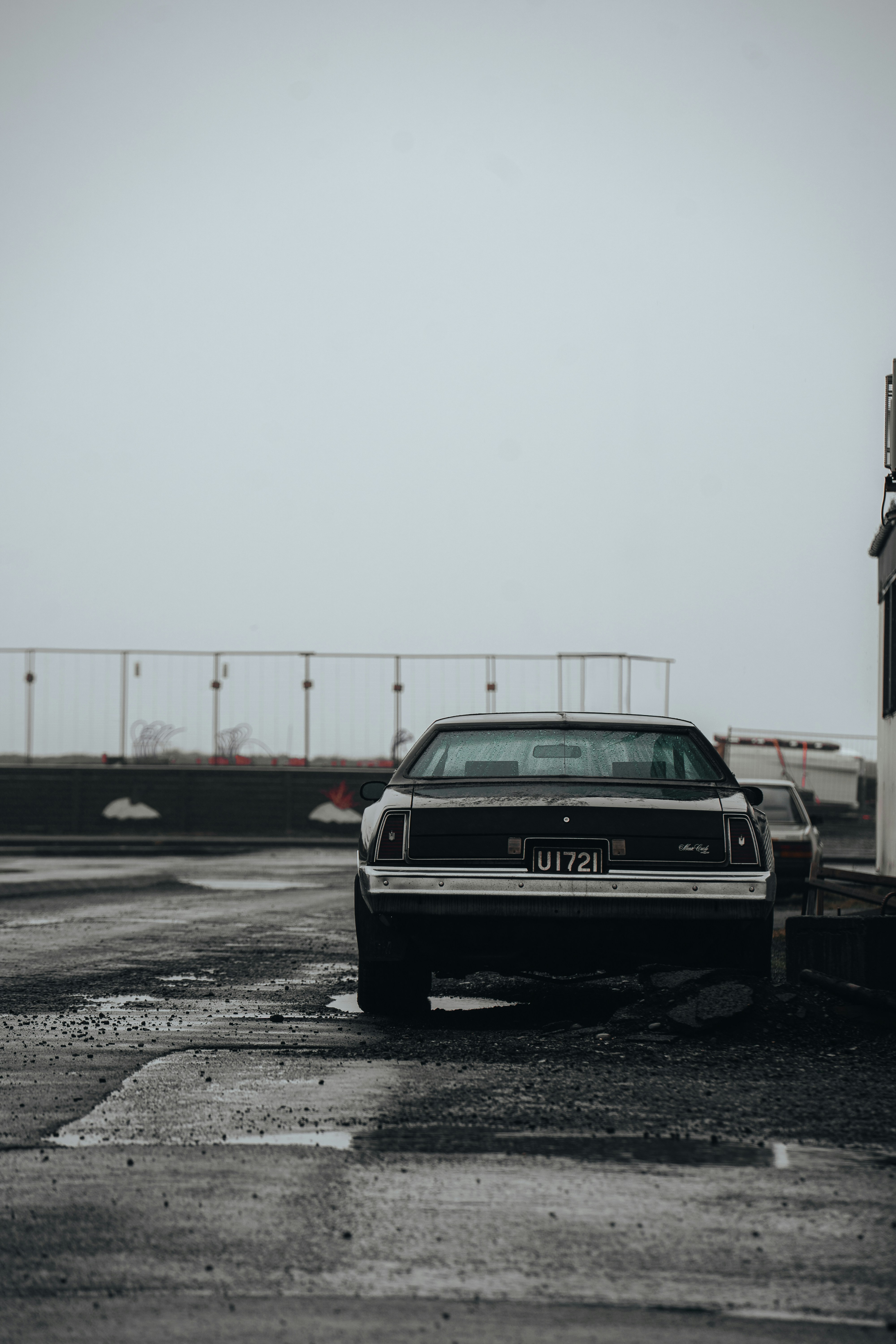 Midnight Parking: A Vintage Sedan Resting by Rain-Slicked Tarmac