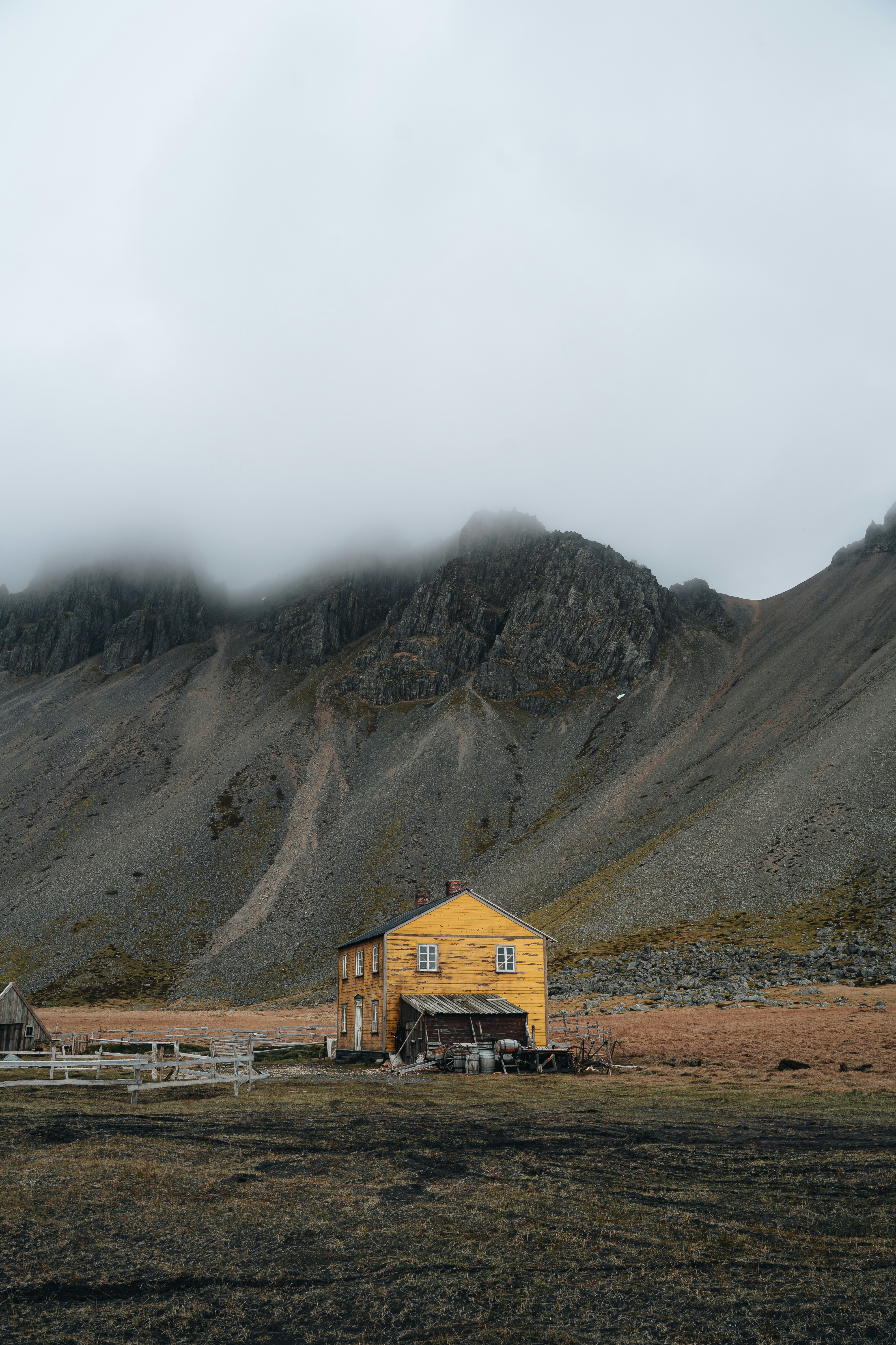 The Lone Yellow House Beneath a Crown of Clouds