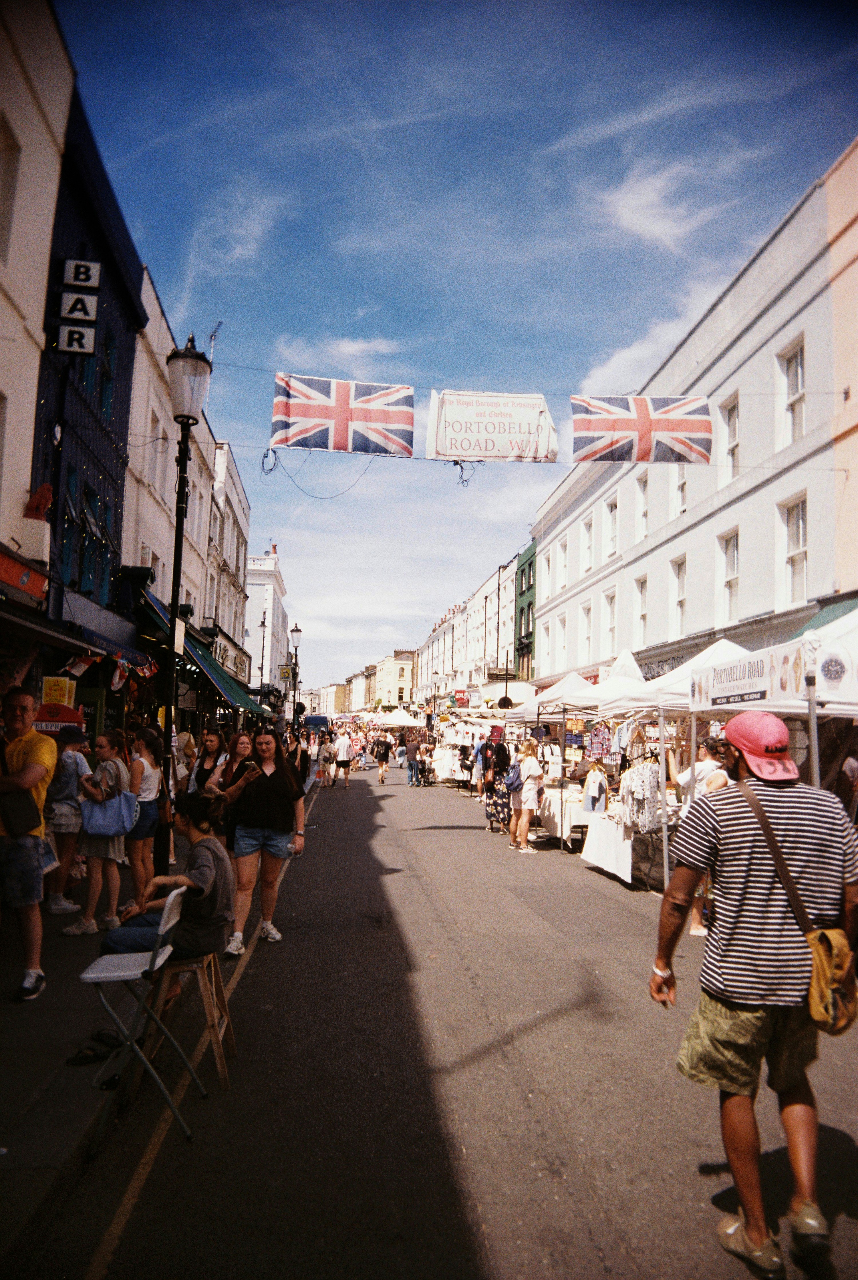 Crowd-Flow Under Union Flags at a Bustling Street Market