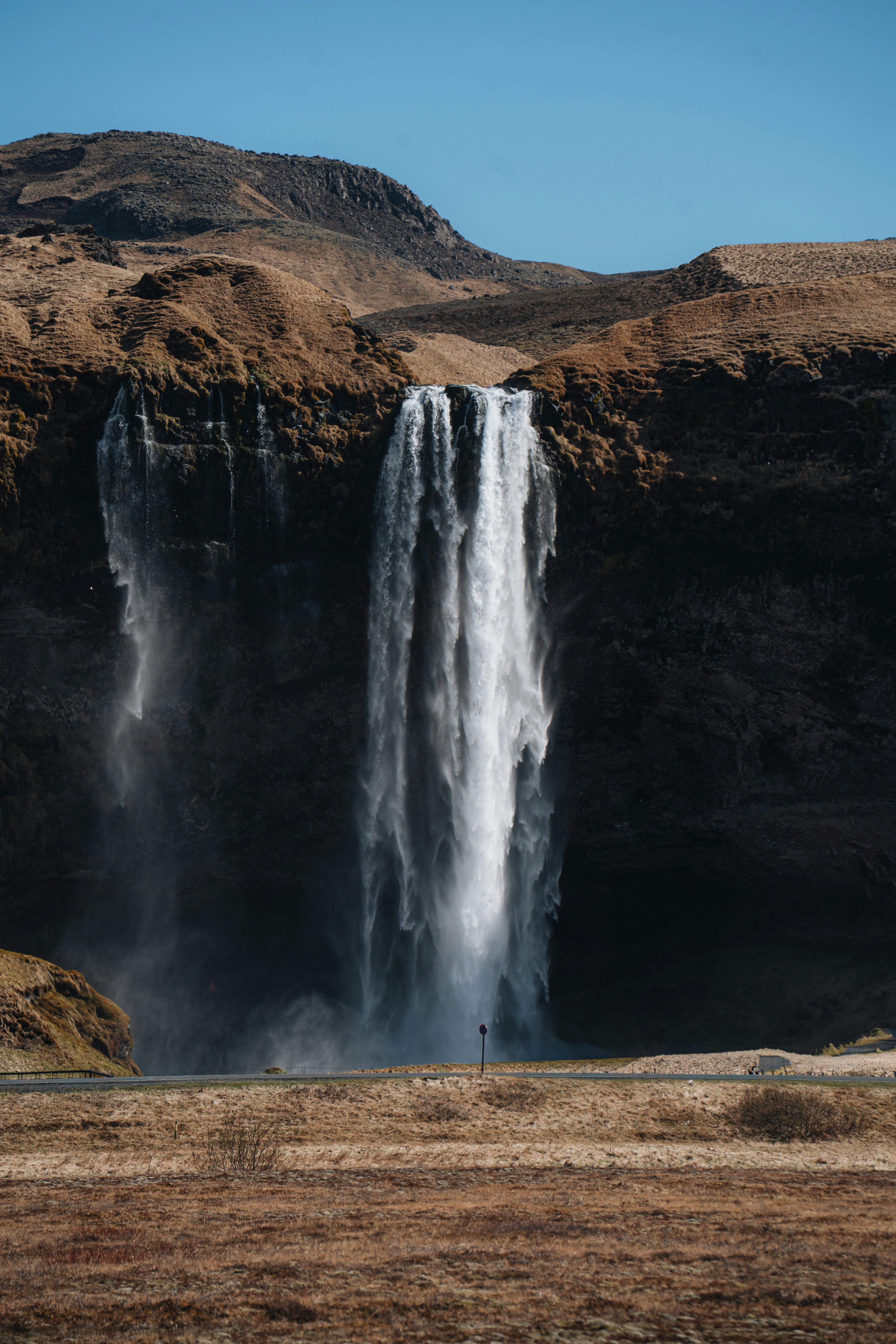 Cascading Veil: A Solitary Waterfall Between Arid Cliffs