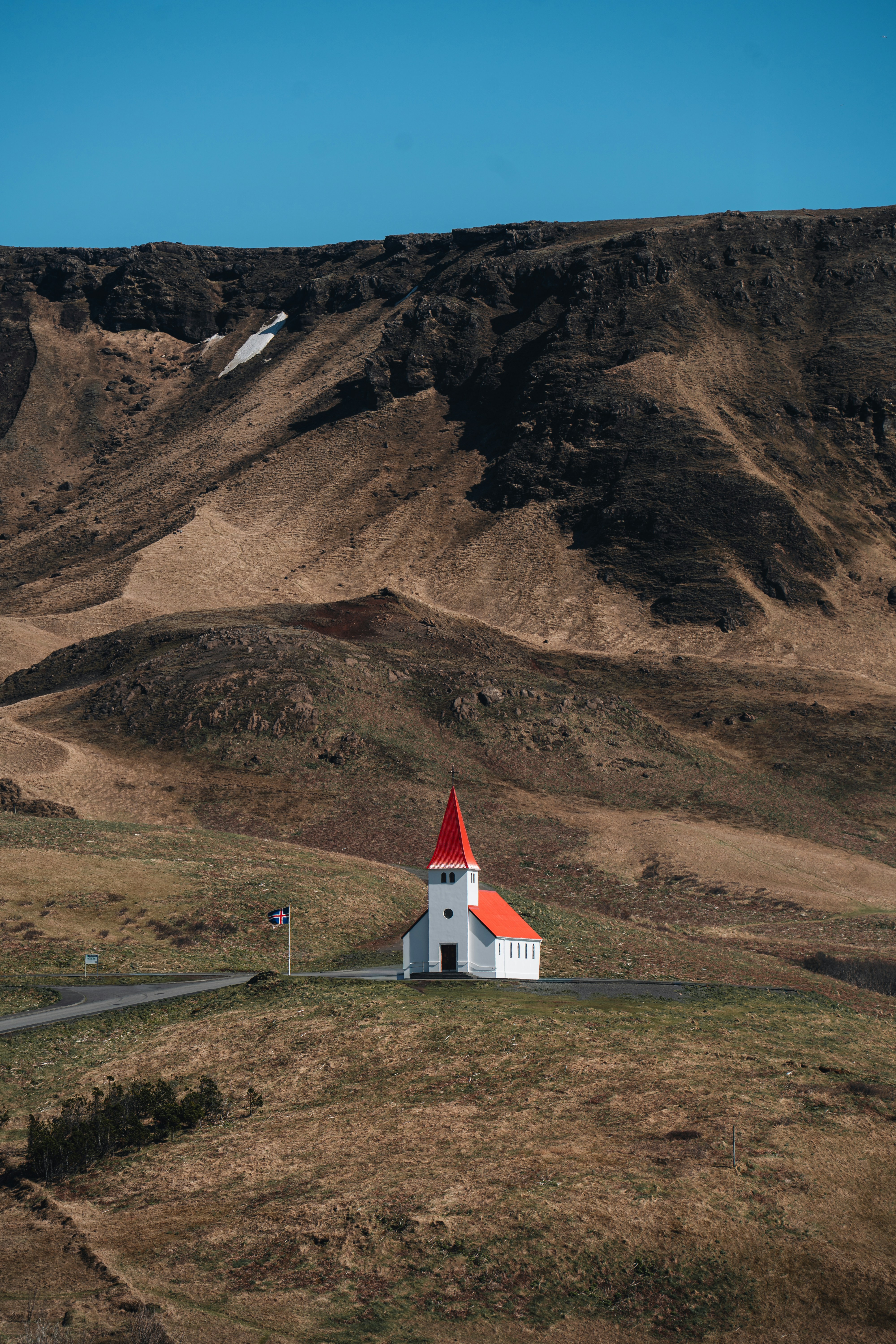 Red-roofed Chapel at the Foot of a Rugged Hill