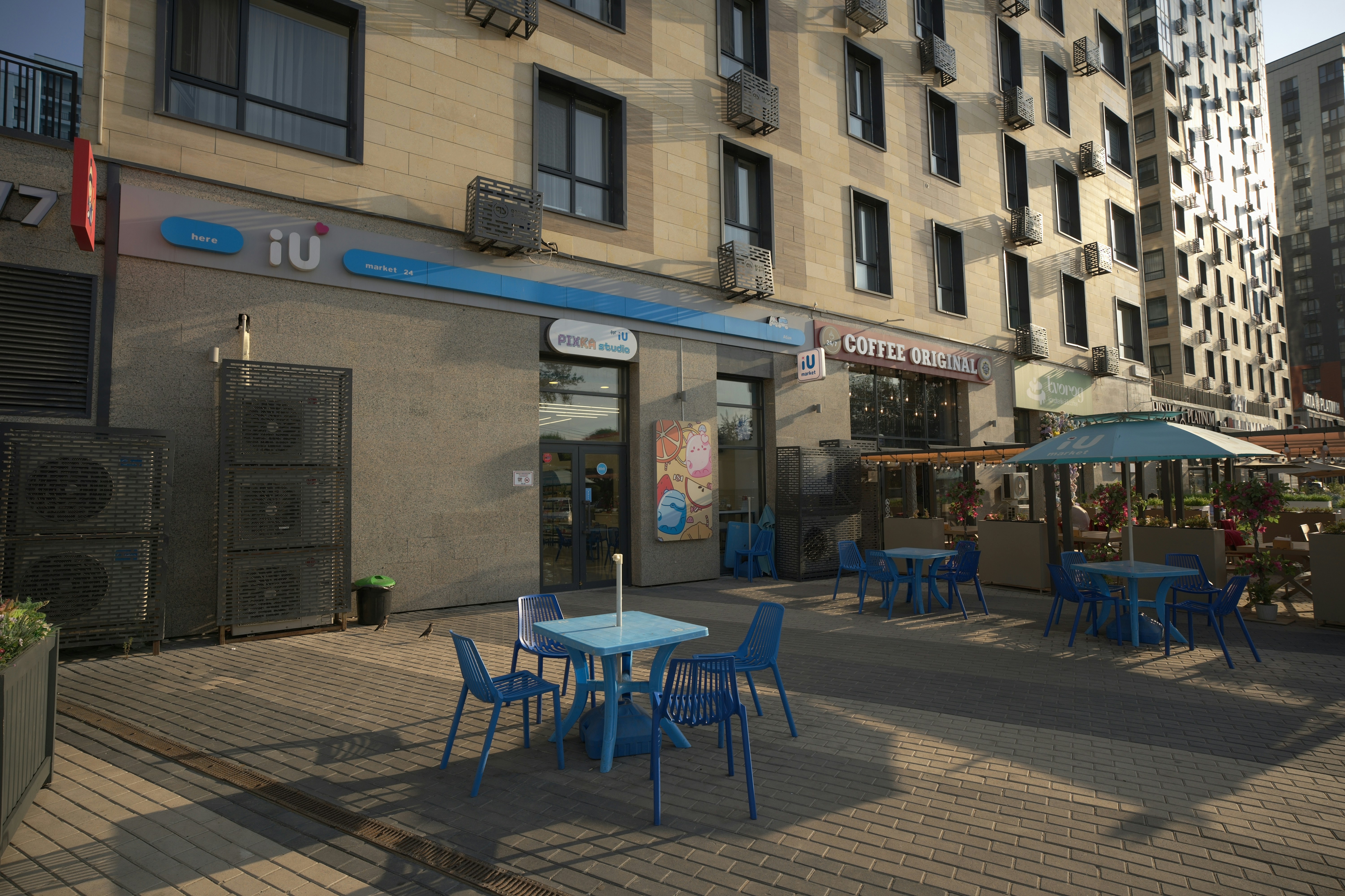 Outdoor street cafe terrace with blue plastic chairs and tables on a sunny day