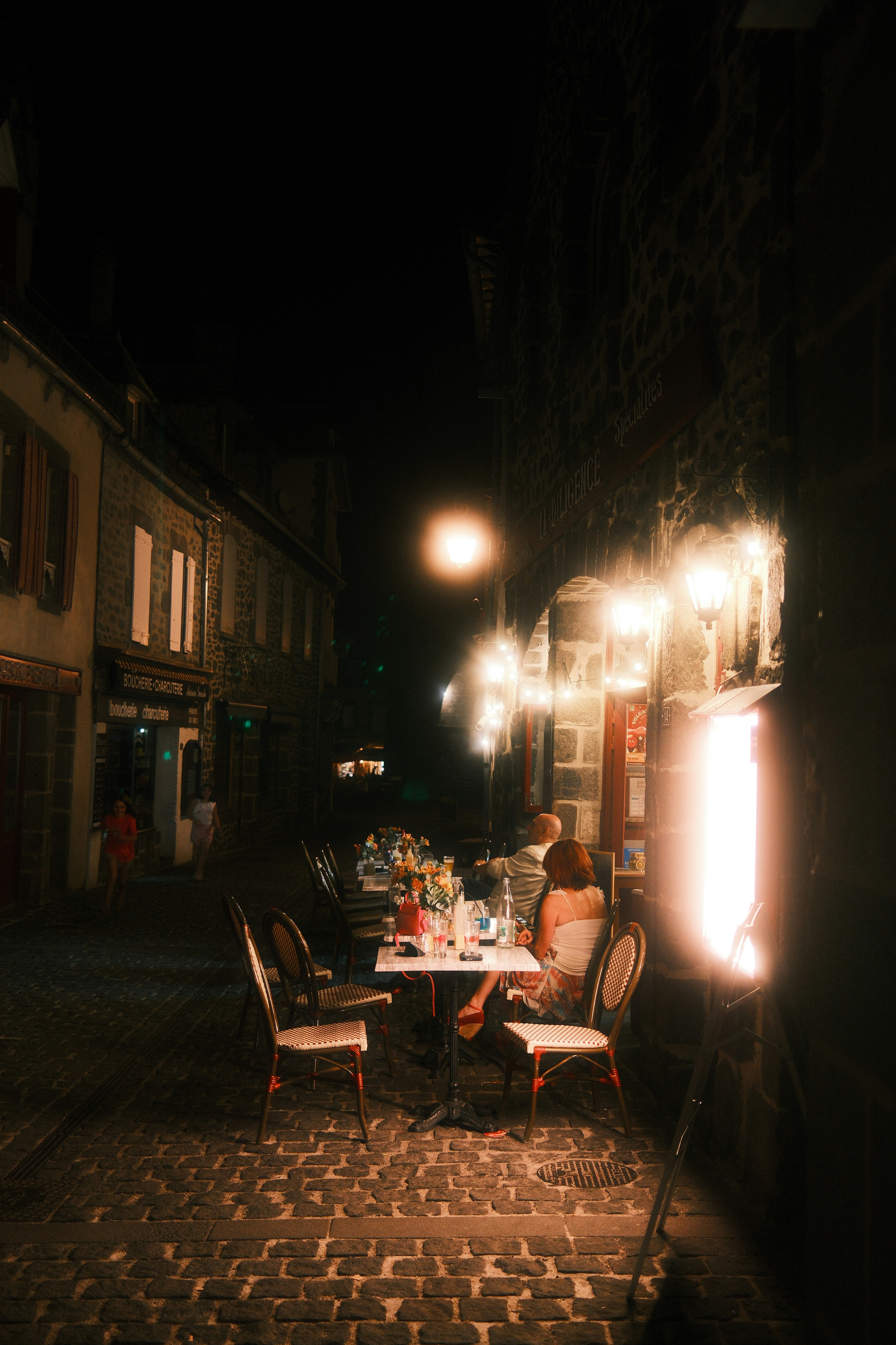 Night Café in a Narrow Cobblestone Alley