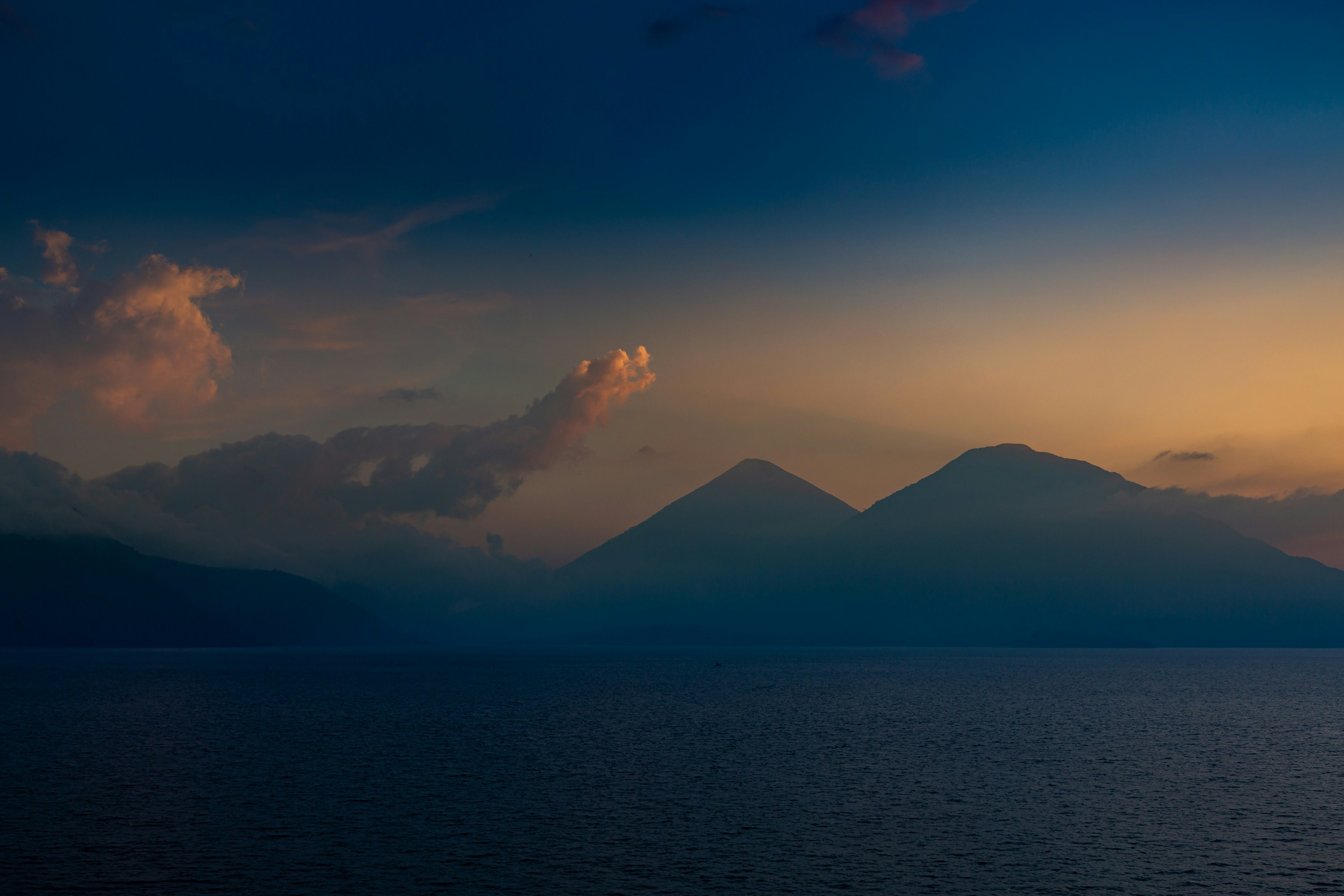 Twin Volcano Silhouette at Dusk over Calm Waters
