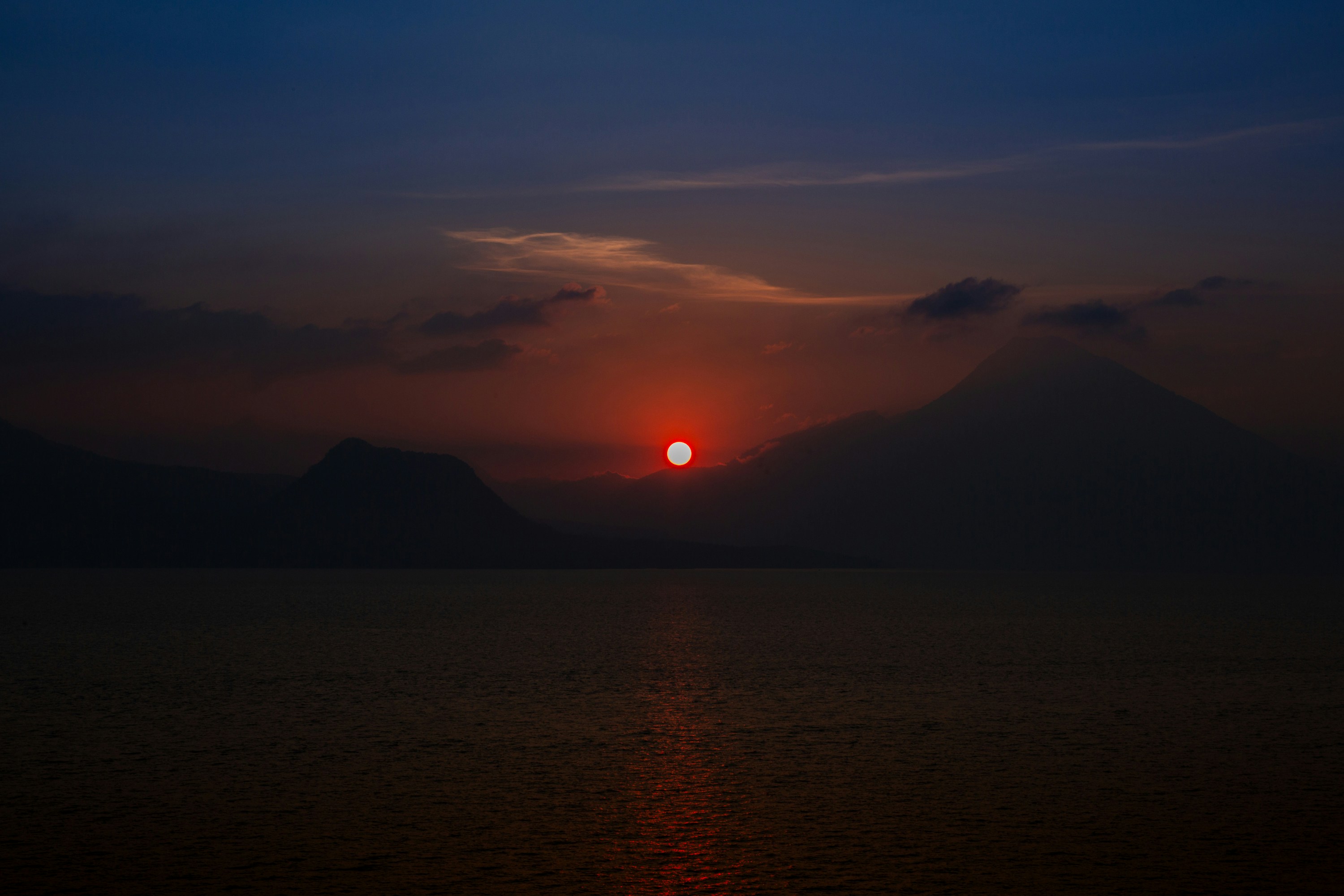Red Sun Over Quiet Waters: A Dusk Silhouette