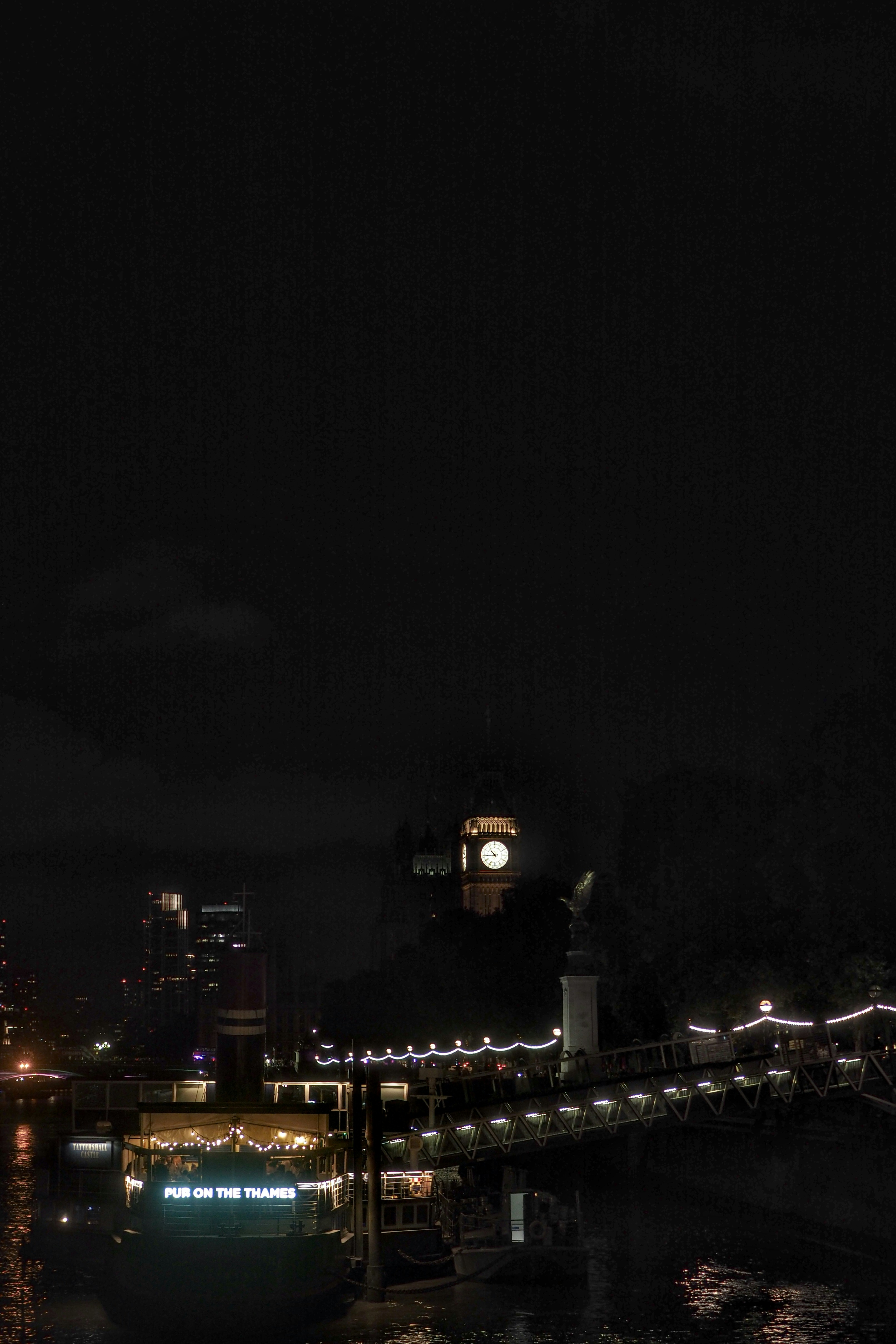 Nighttime Thames Crossing: A Clock Tower Beacon by the River
