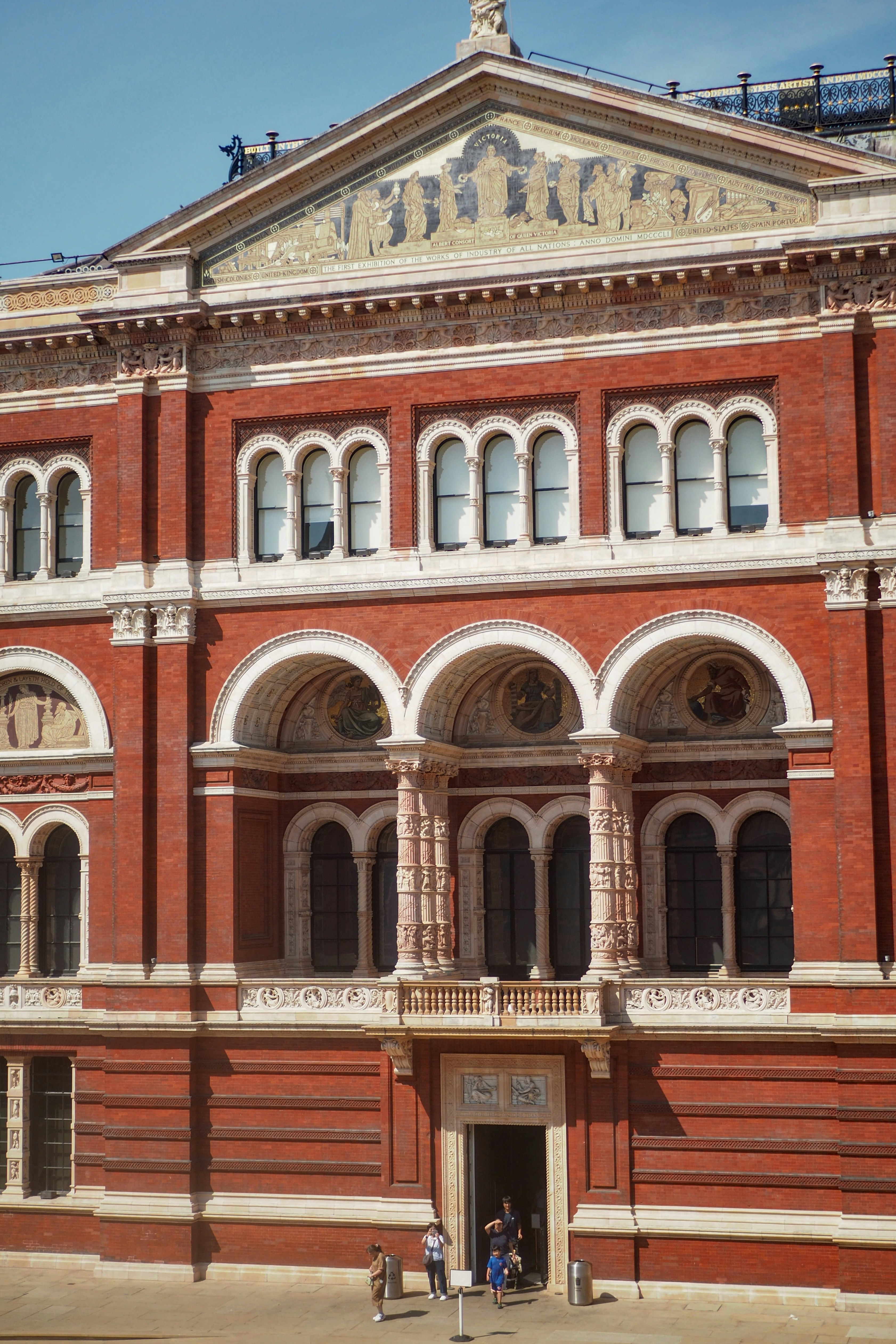 Red-brick Facade: Arched Entryway Under Classical Pediment
