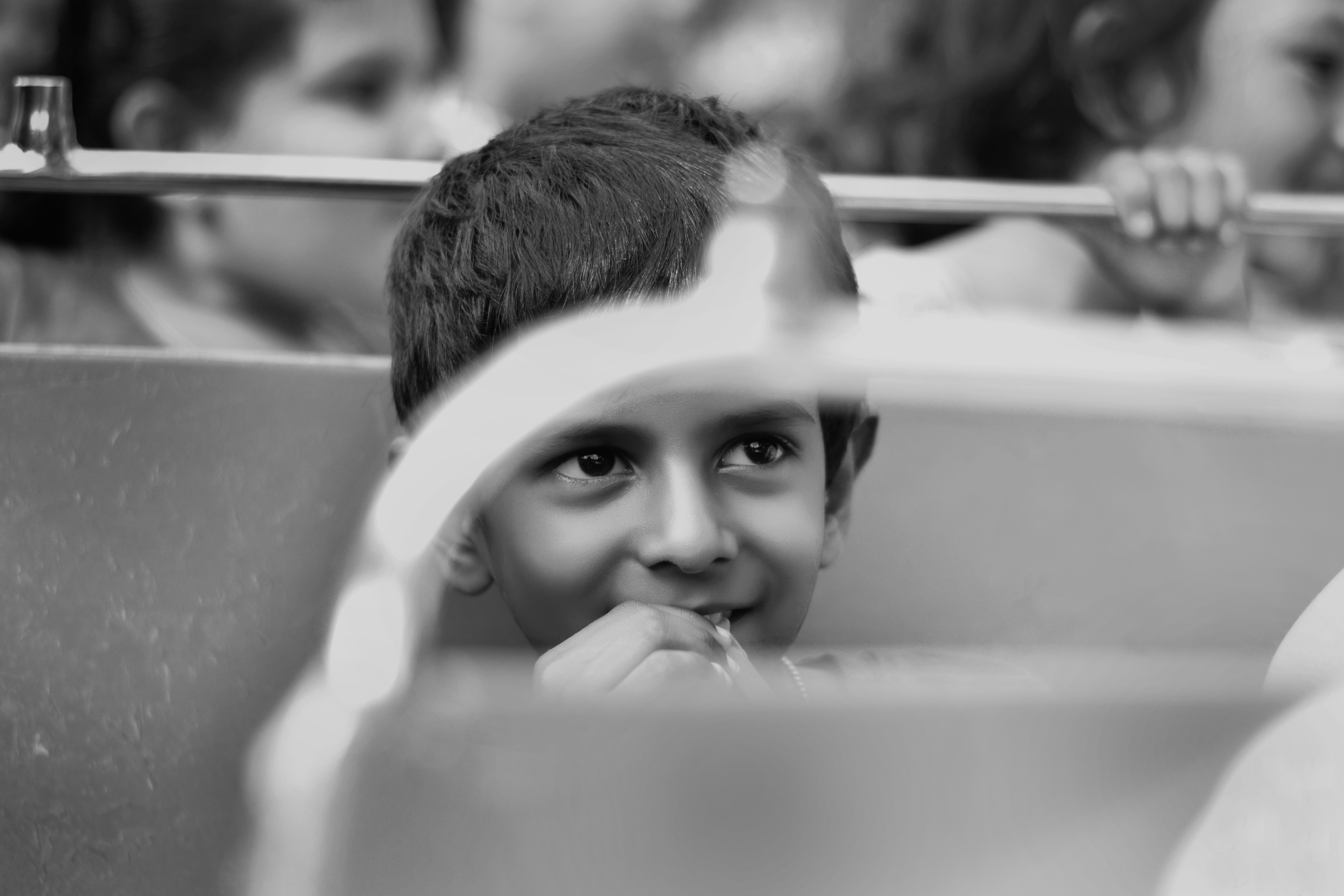 Eyes Behind the Ring: a child's quiet smile at the edge of a crowd