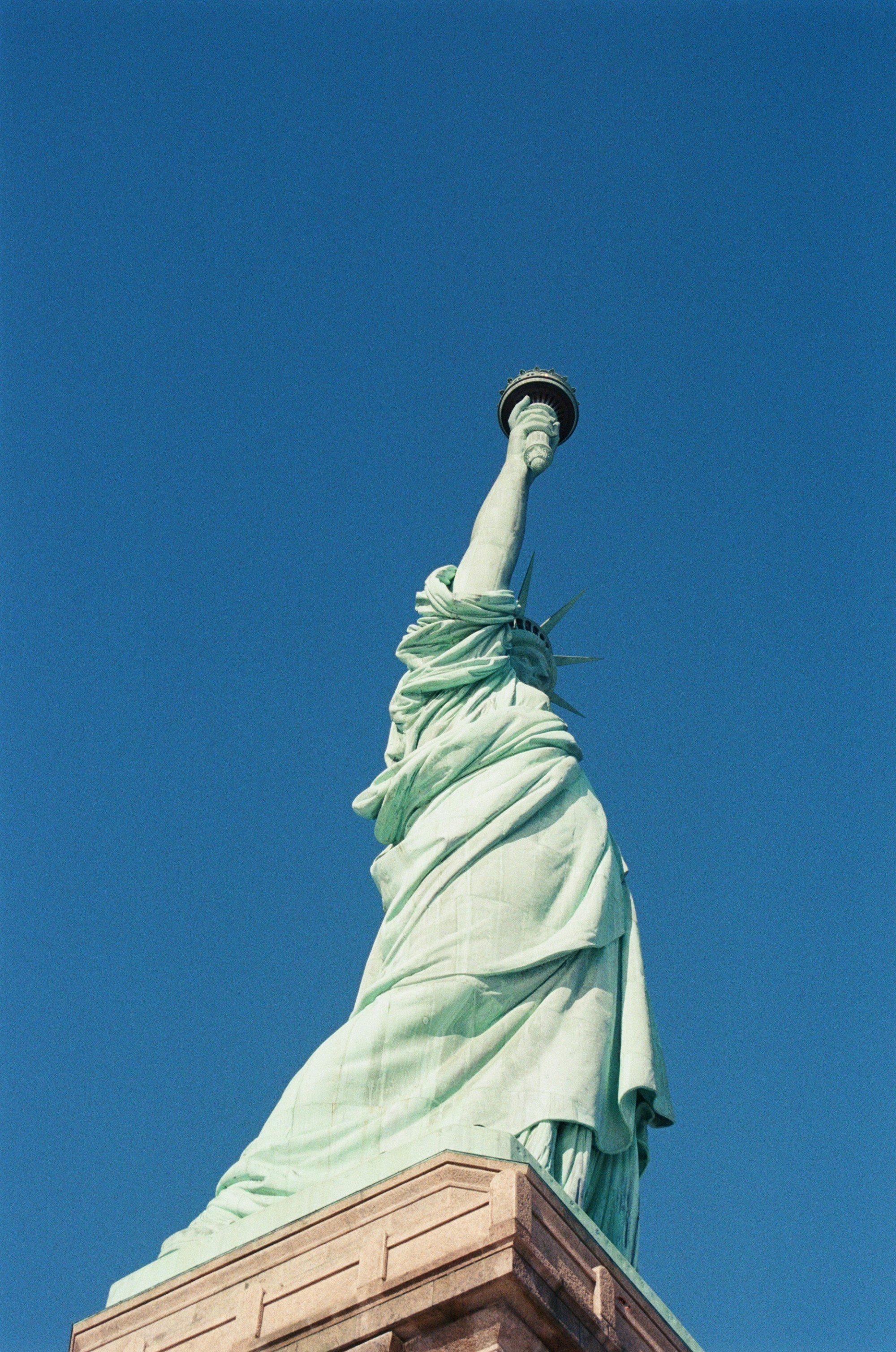 The Statue of Liberty holding a torch against a clear blue sky in New York