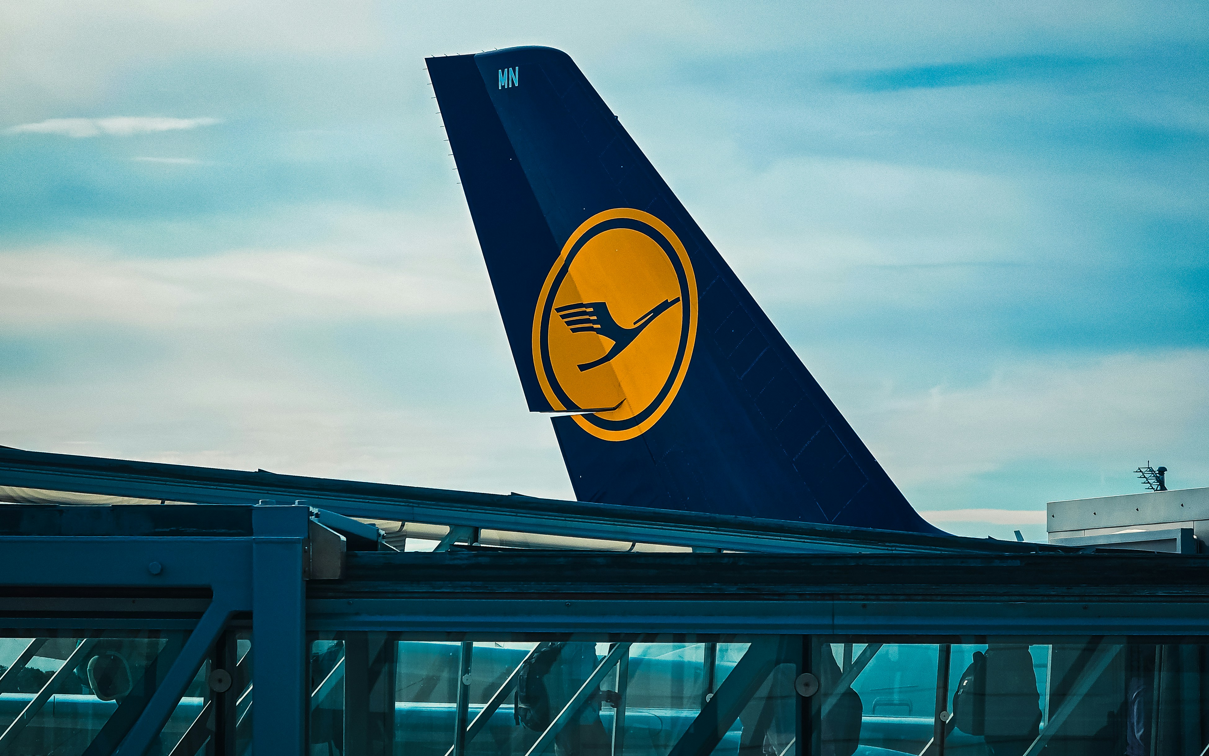 Tailfin in Focus: A Lufthansa A340's Sleek Emblem Rising Above the Jetway