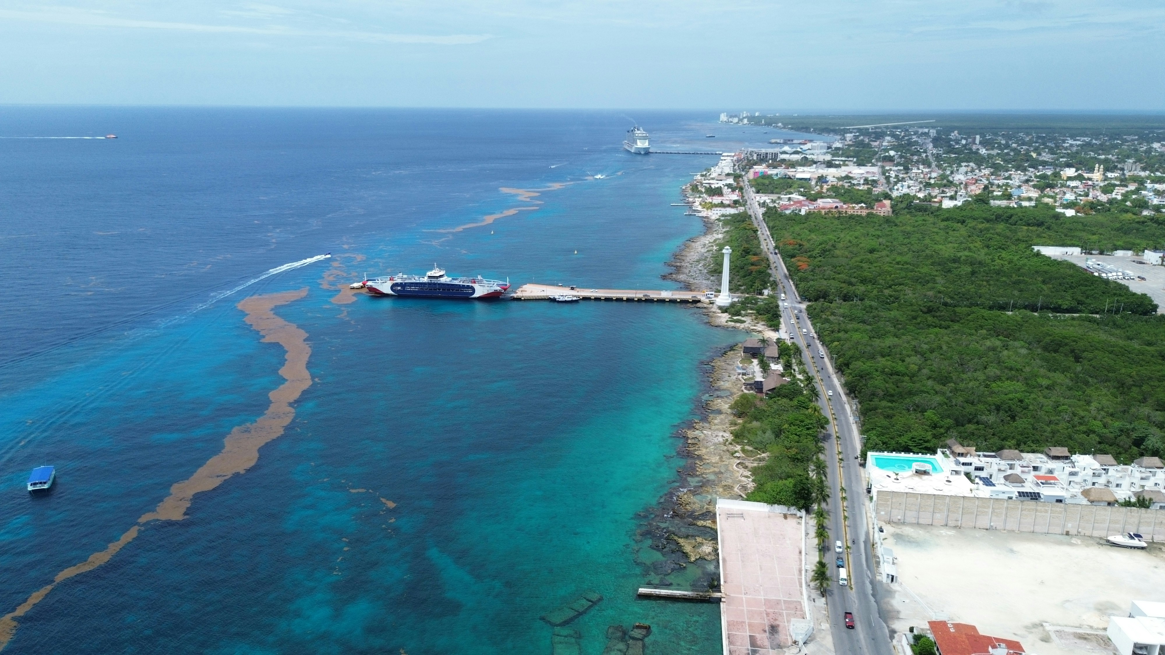 Coastal Harborline: Aerial View of Turquoise Shallows and Urban Strip