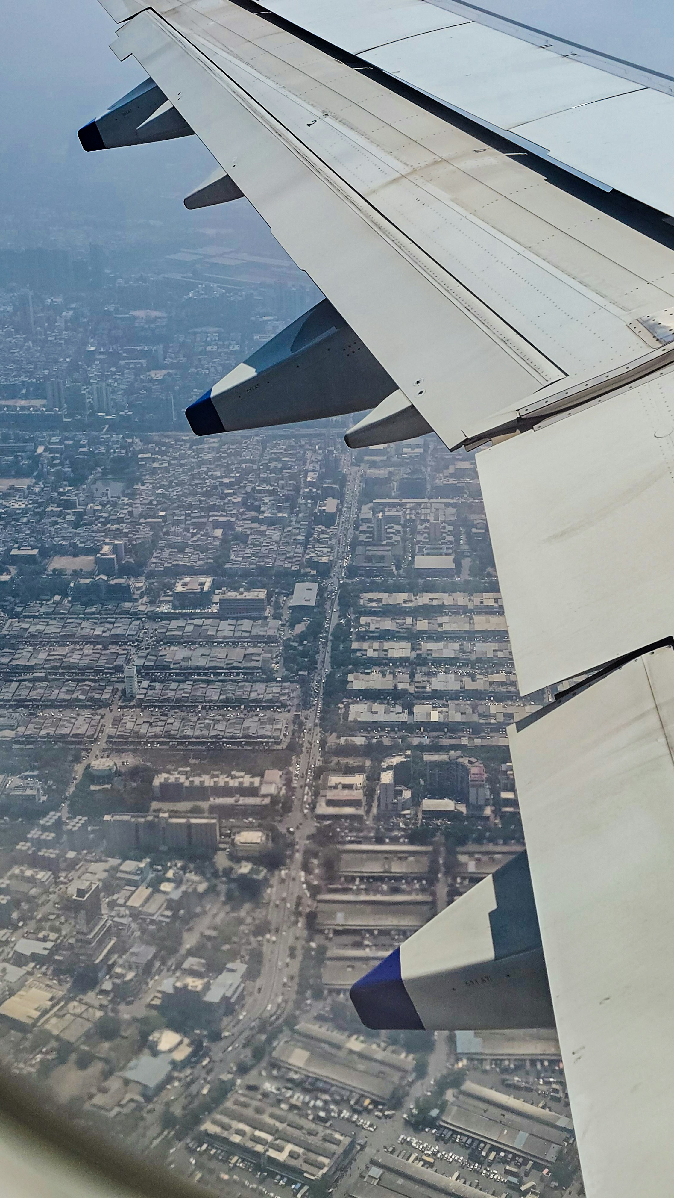 Aerial View Through Aircraft Wing: City Gridded Beneath