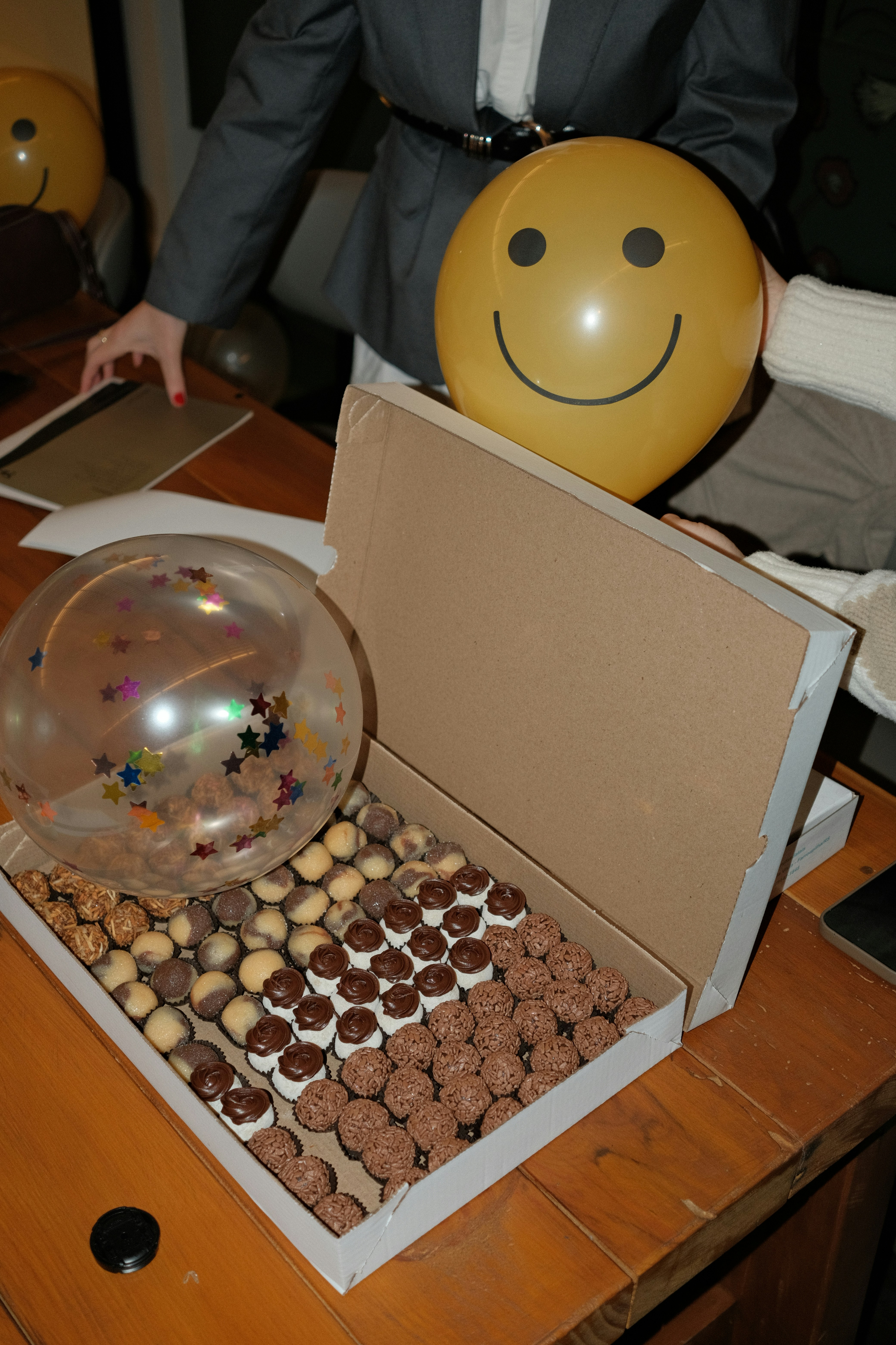 Smiley Balloon Over a Box of Treats at a Birthday Setup