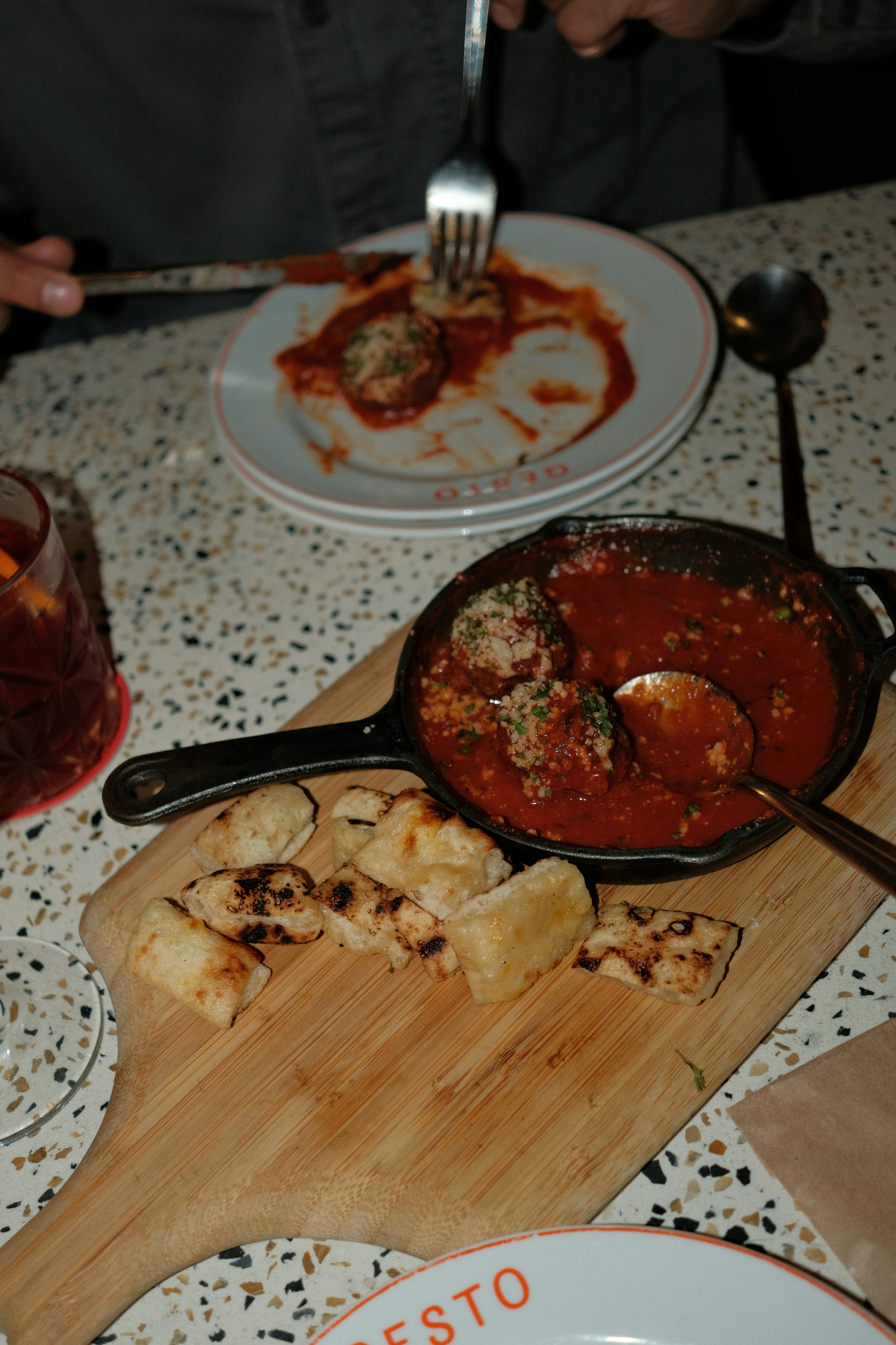 Meatballs in tomato sauce in a cast iron skillet with toasted bread on a board