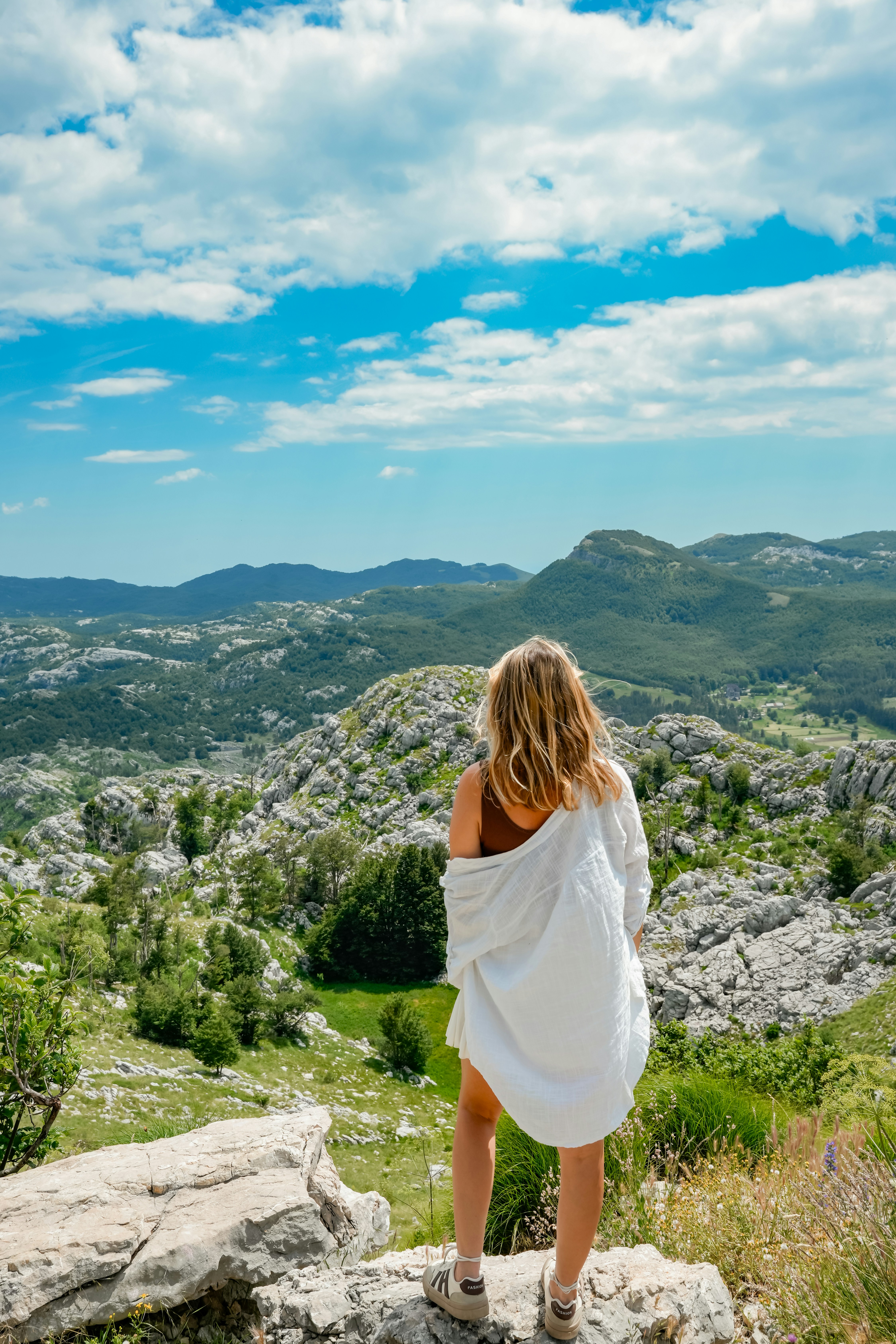White shirted wanderer at a sunlit limestone ridge