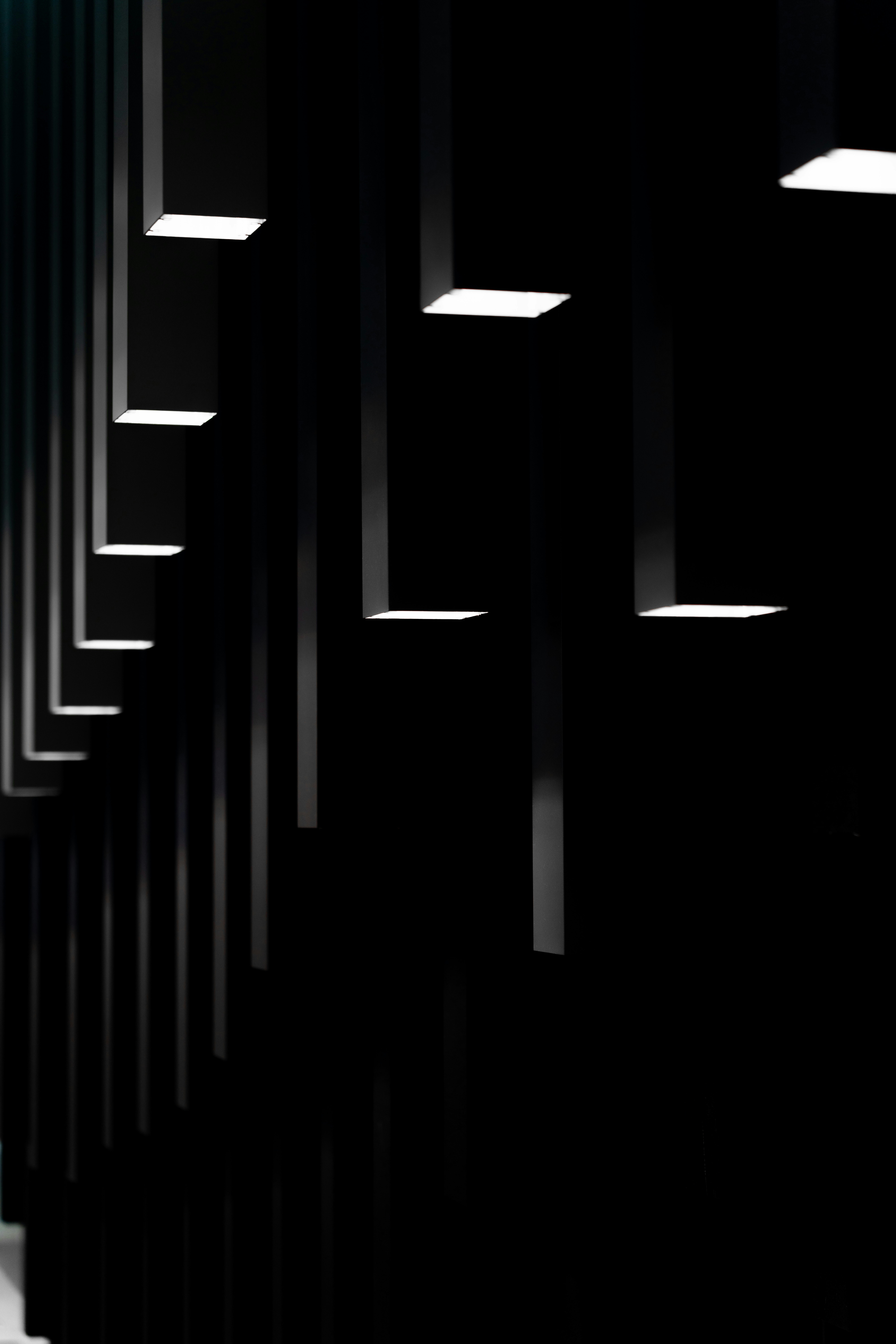 Monochrome Echoes: Vertical Light Ribbons in Deep Shadow