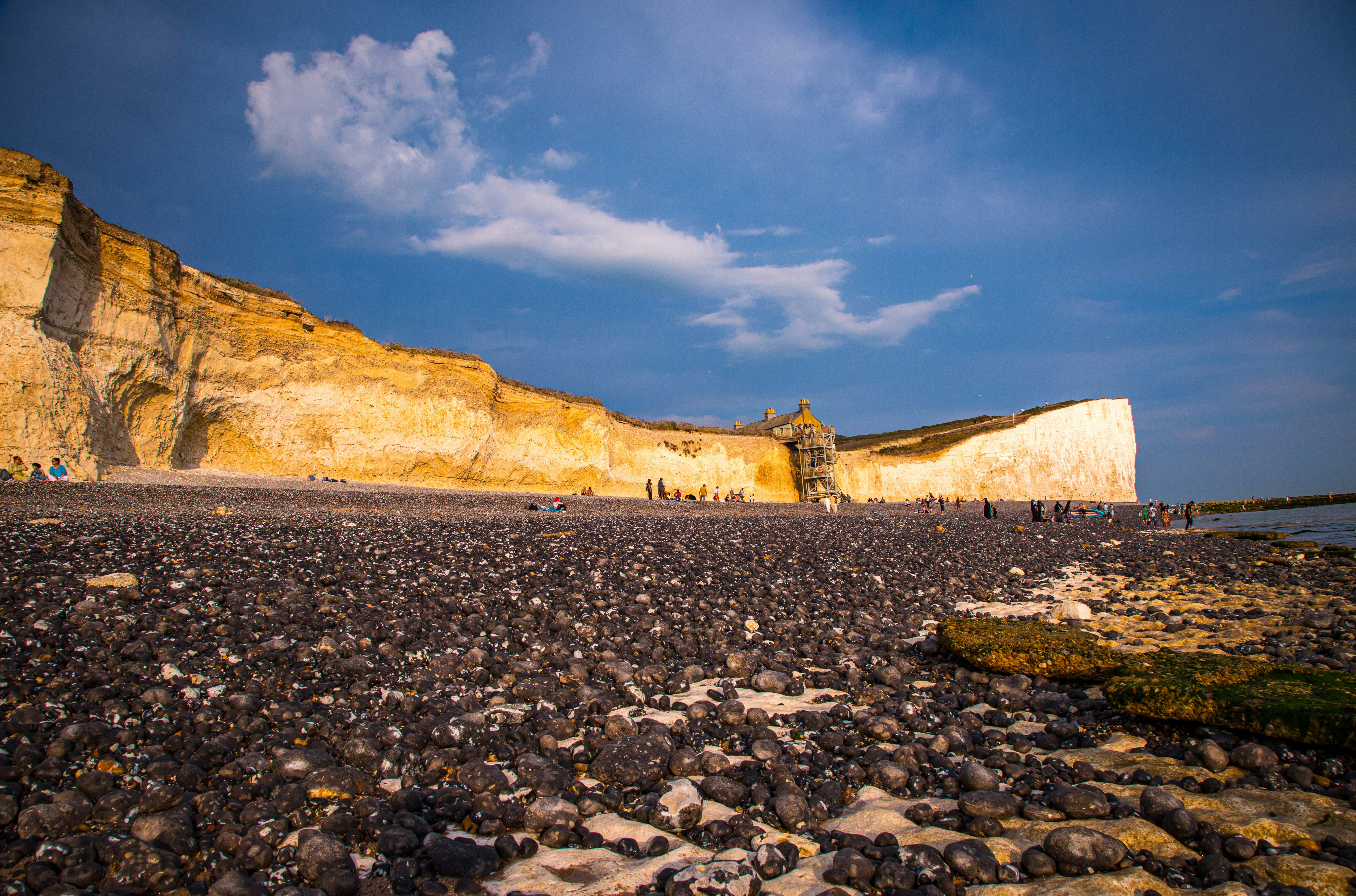 Cliffside Shore: Limestone Walls and Pebble Beach at Golden Hour