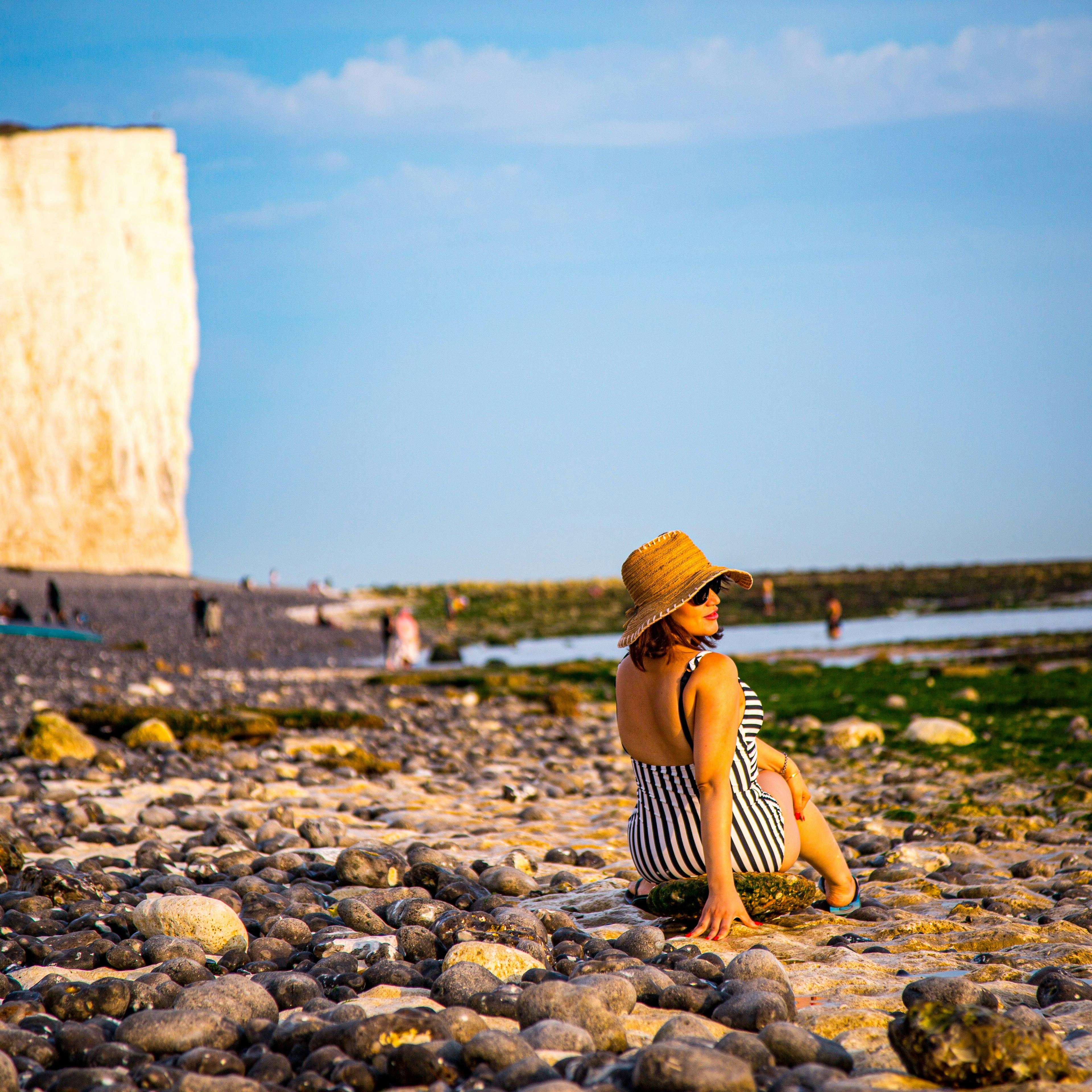 Sheer Seaside Presence: Sunlit Stripes and a Straw Hat