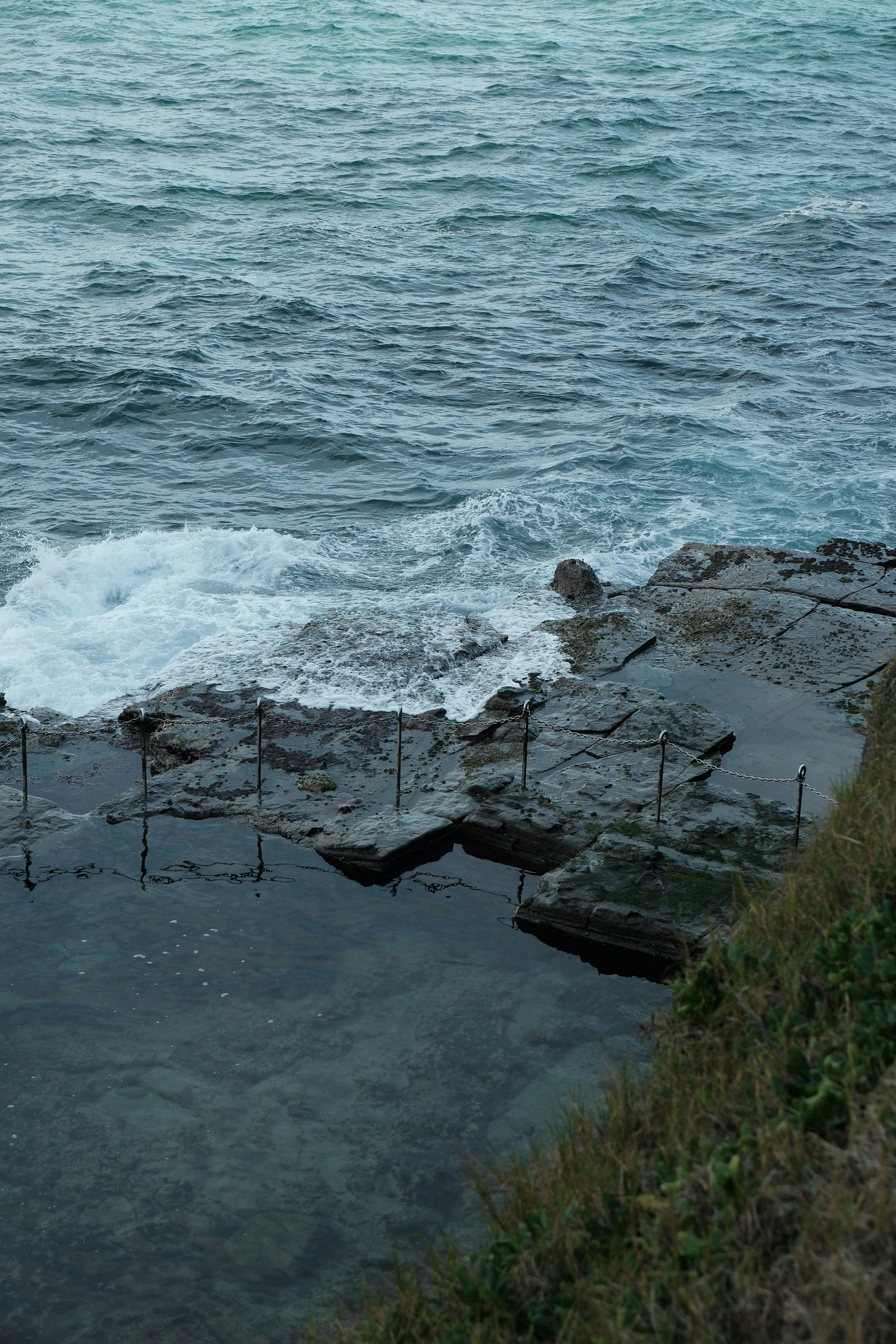 Tidebreak at the Edge: Weathered Rocks and Calm Sea