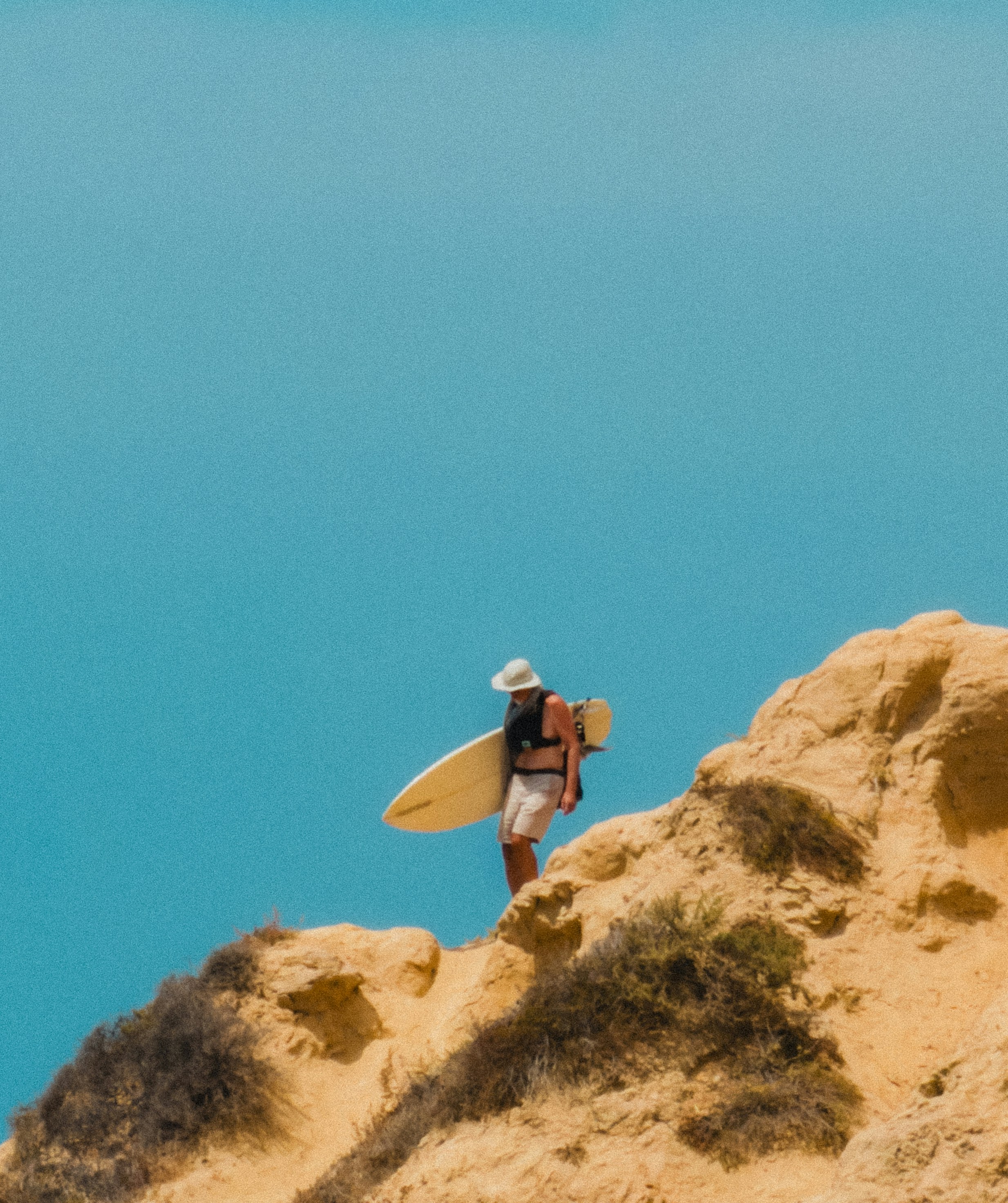 Surfer at the Crest: A Lone Rider on Sunlit Cliffs