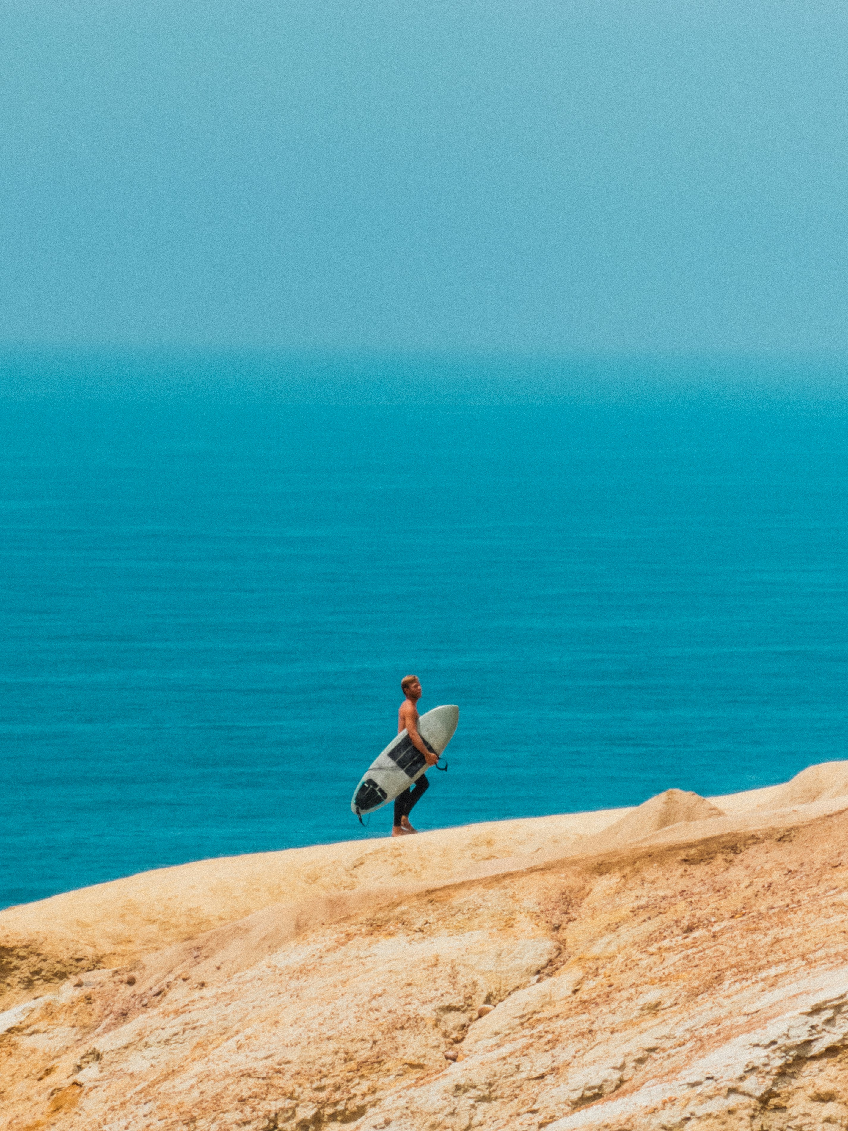 Solo Surfer at Dune’s Edge: A Quiet Blue Horizon