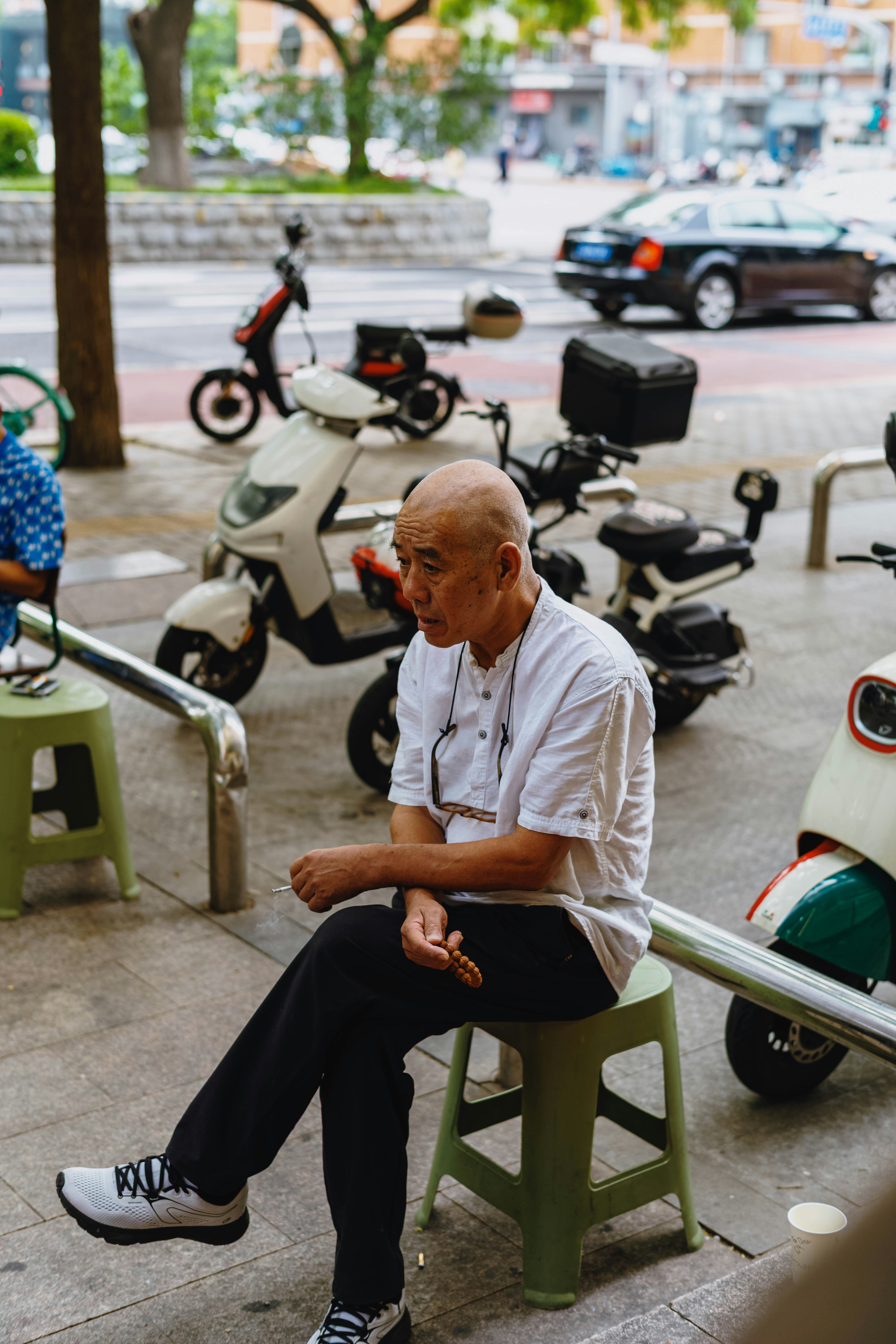 Quiet Moment on the Bus Stop: Elderly Man in White Shirts and Sneakers