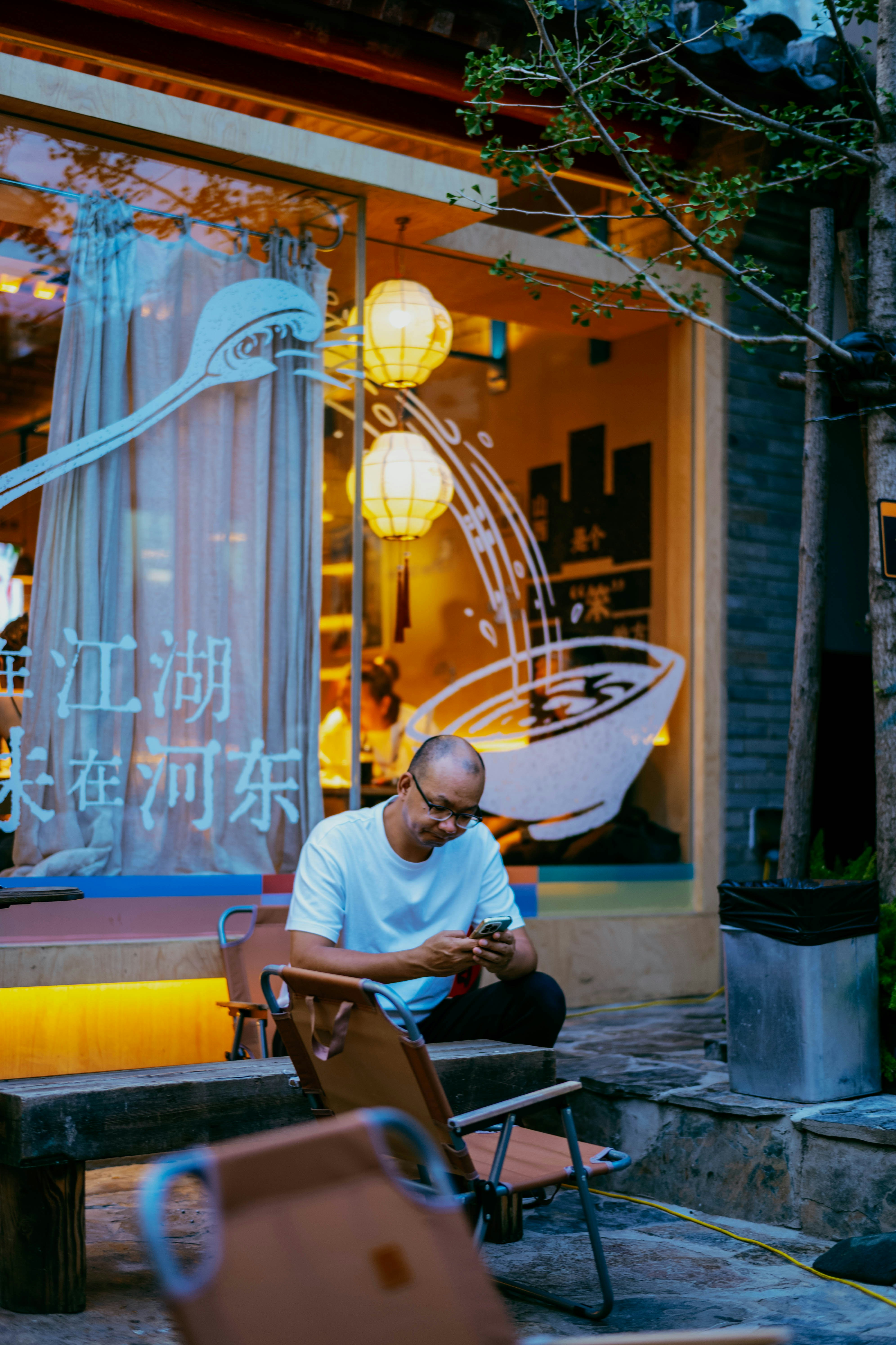Urban Quiet: A Man in White at a Lit Café