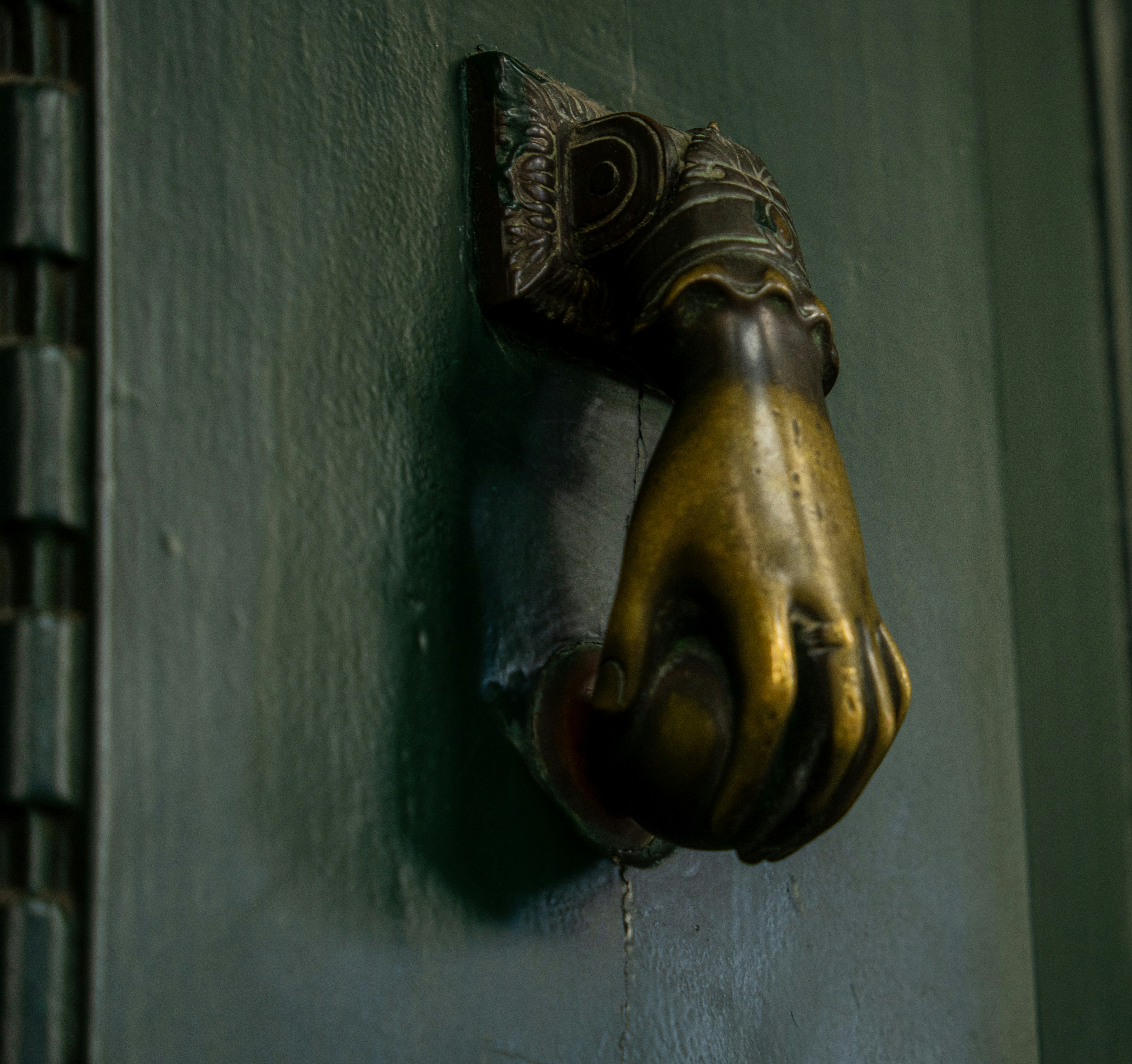 Bronze Claw Door Knocker on Aged Green Gate