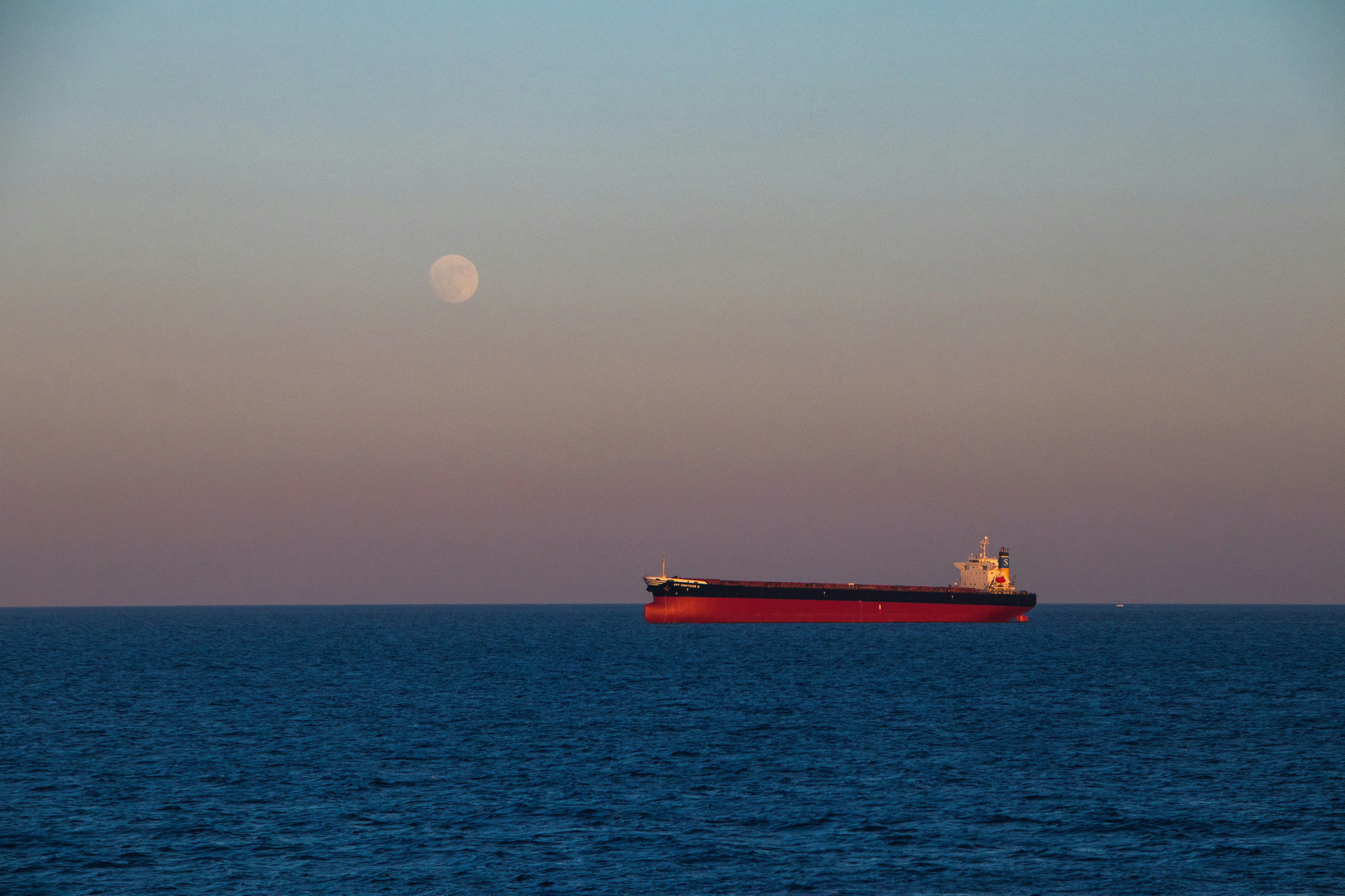 Moonrise over a solitary freighter