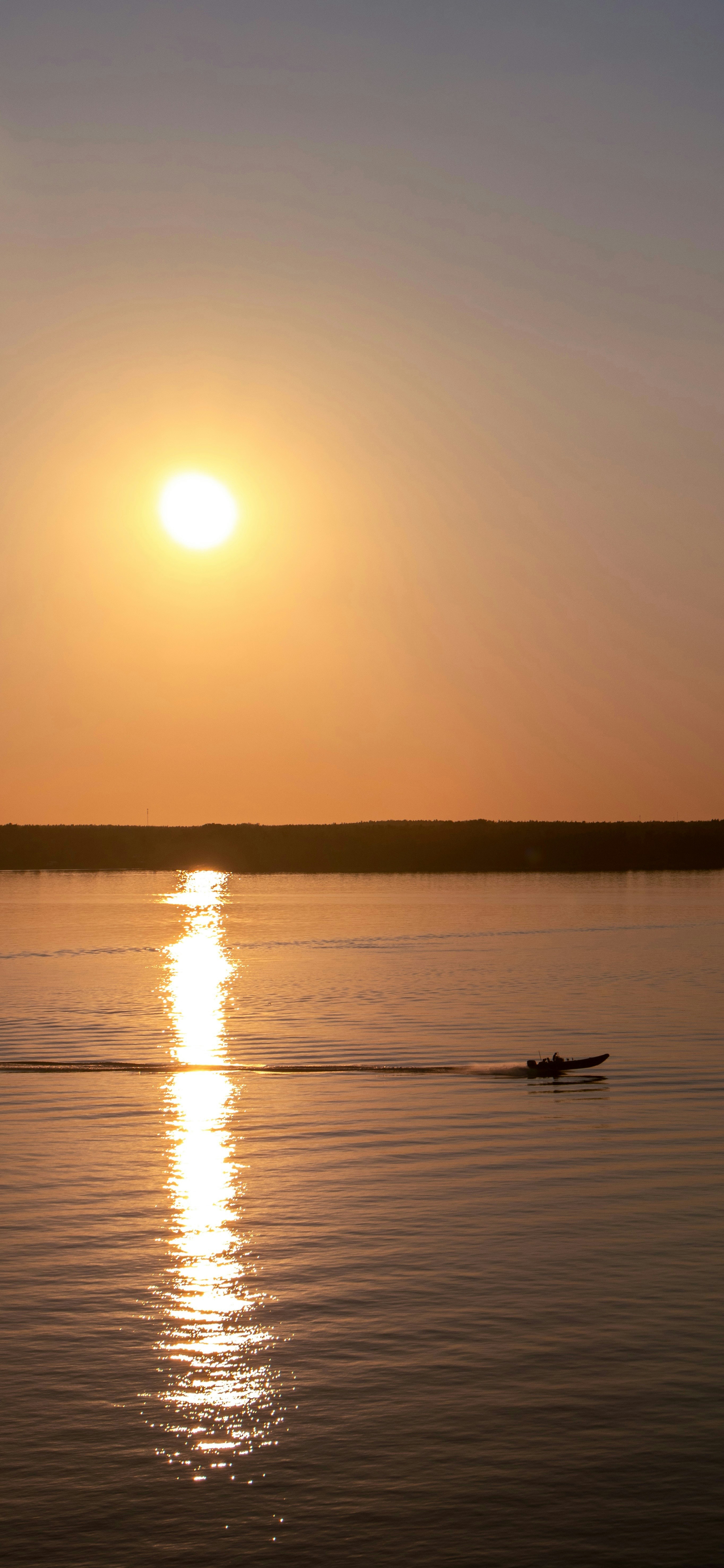 Gliding at Sundown: A lone boat Traces a Golden Wake