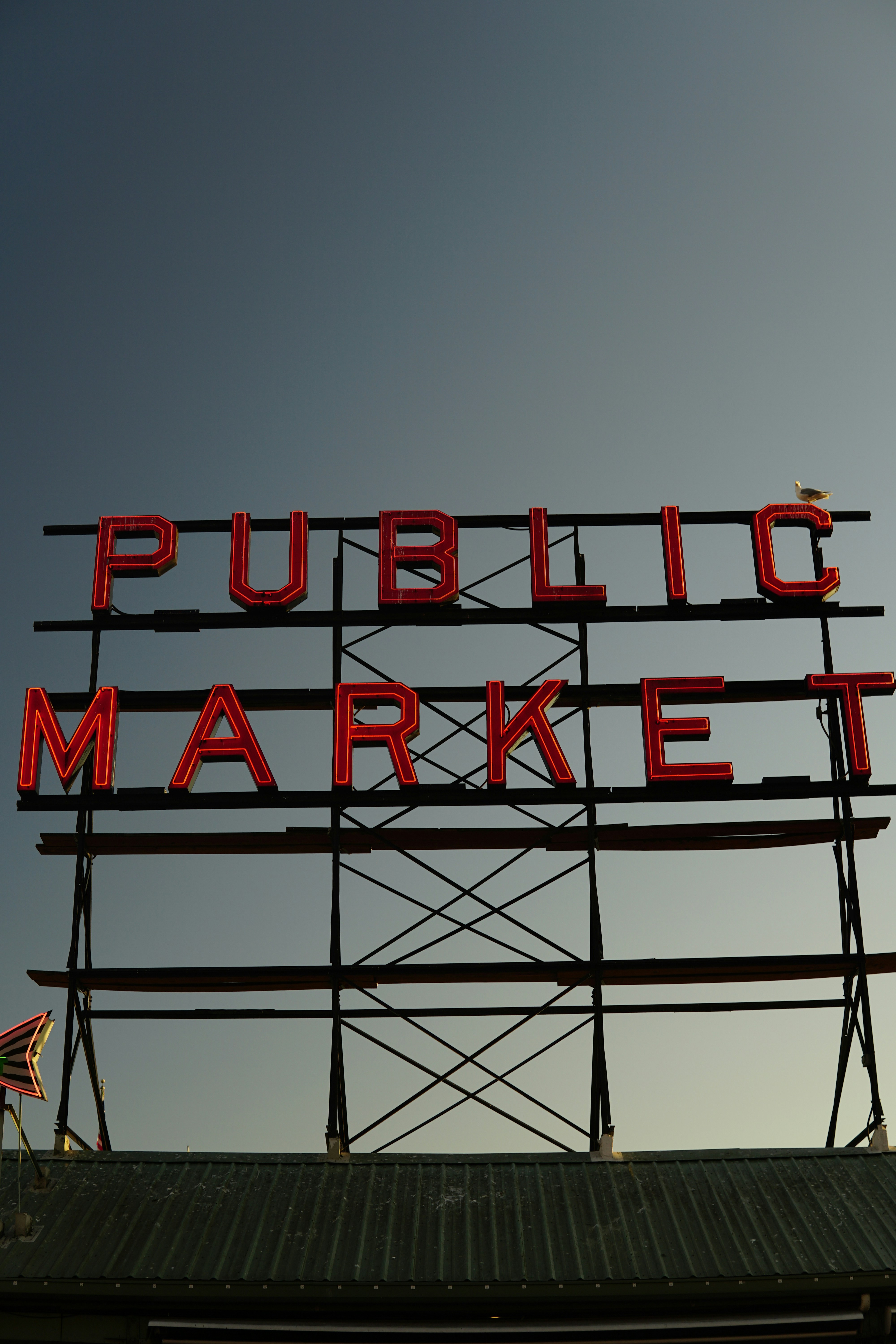 Rusted Steel Skyline: The Public Market Neon Sign Against a Quiet Sky