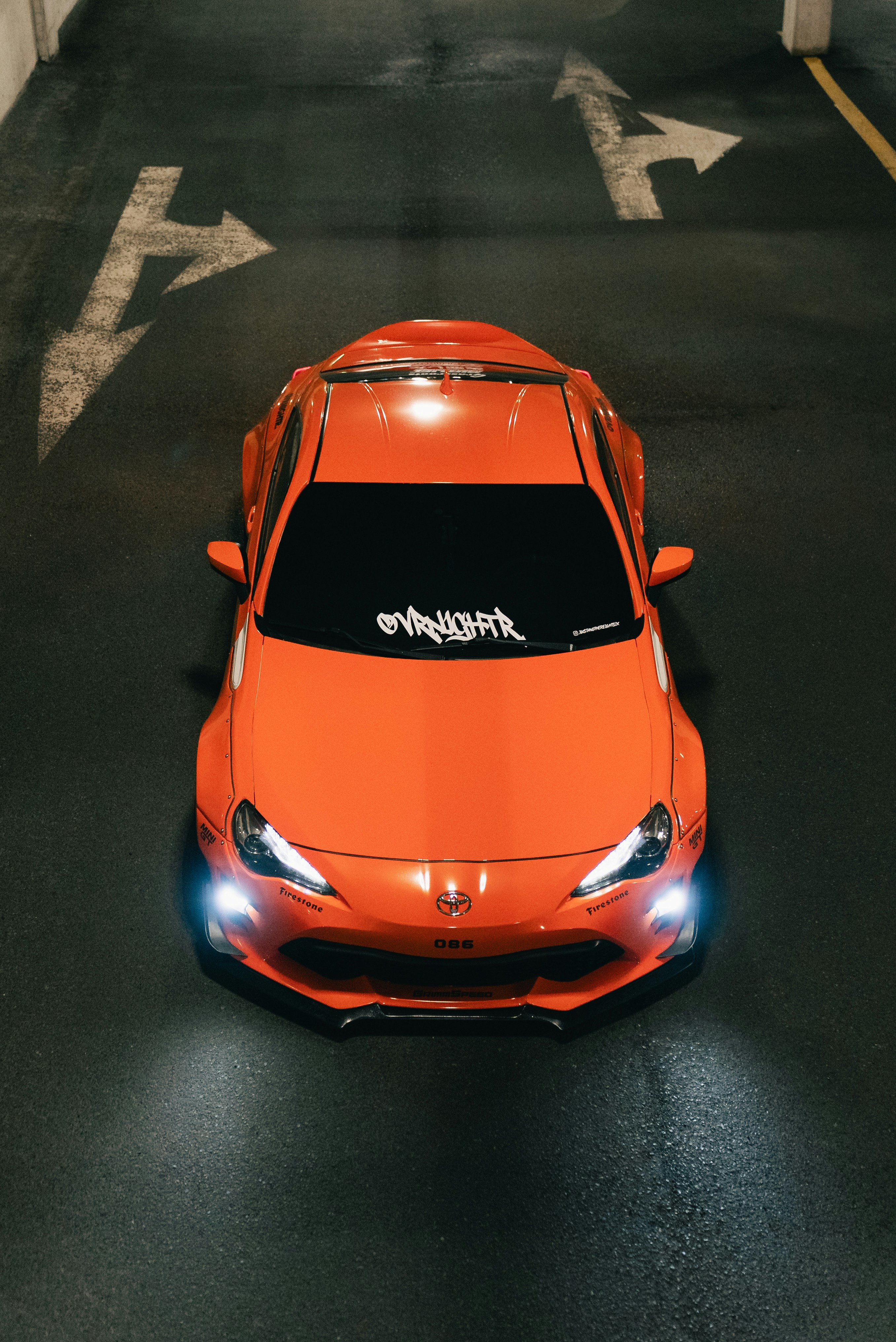 Top-Down Orange Racer: A Bold Foreground in a Parking Lot