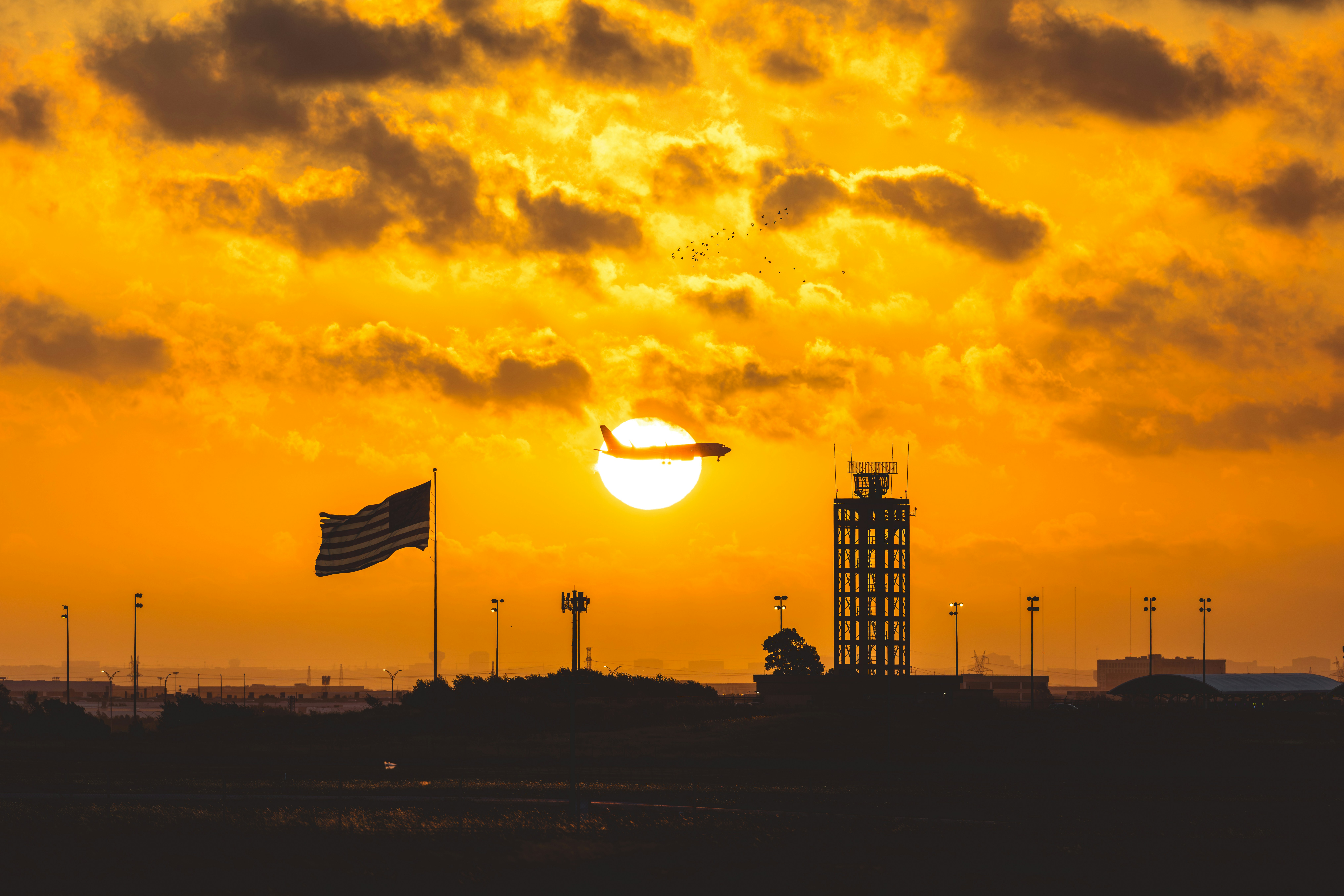 Sunset Sentinel: The Flag and Tower Against a Gilded Sky