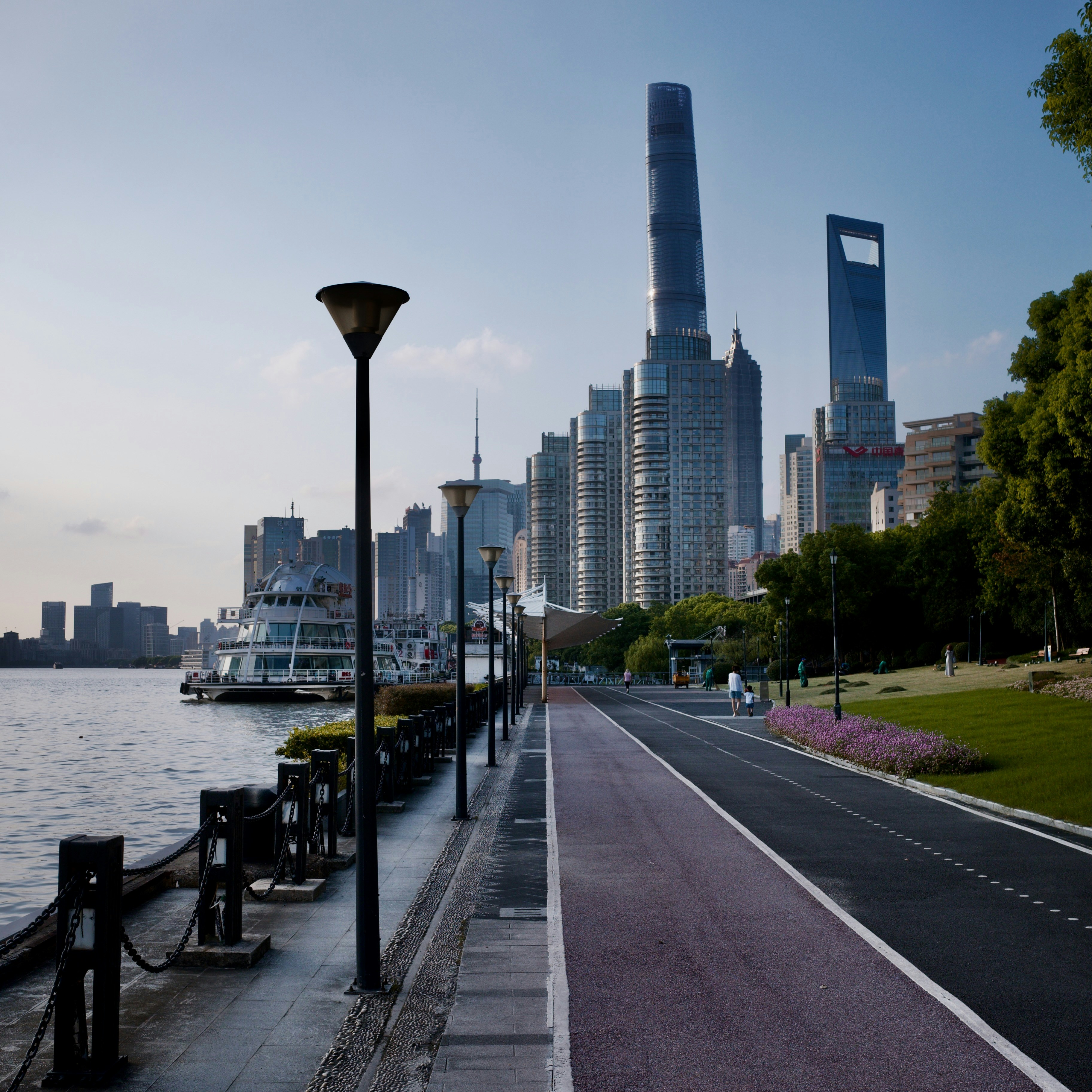 A riverside promenade toward a modern skyline