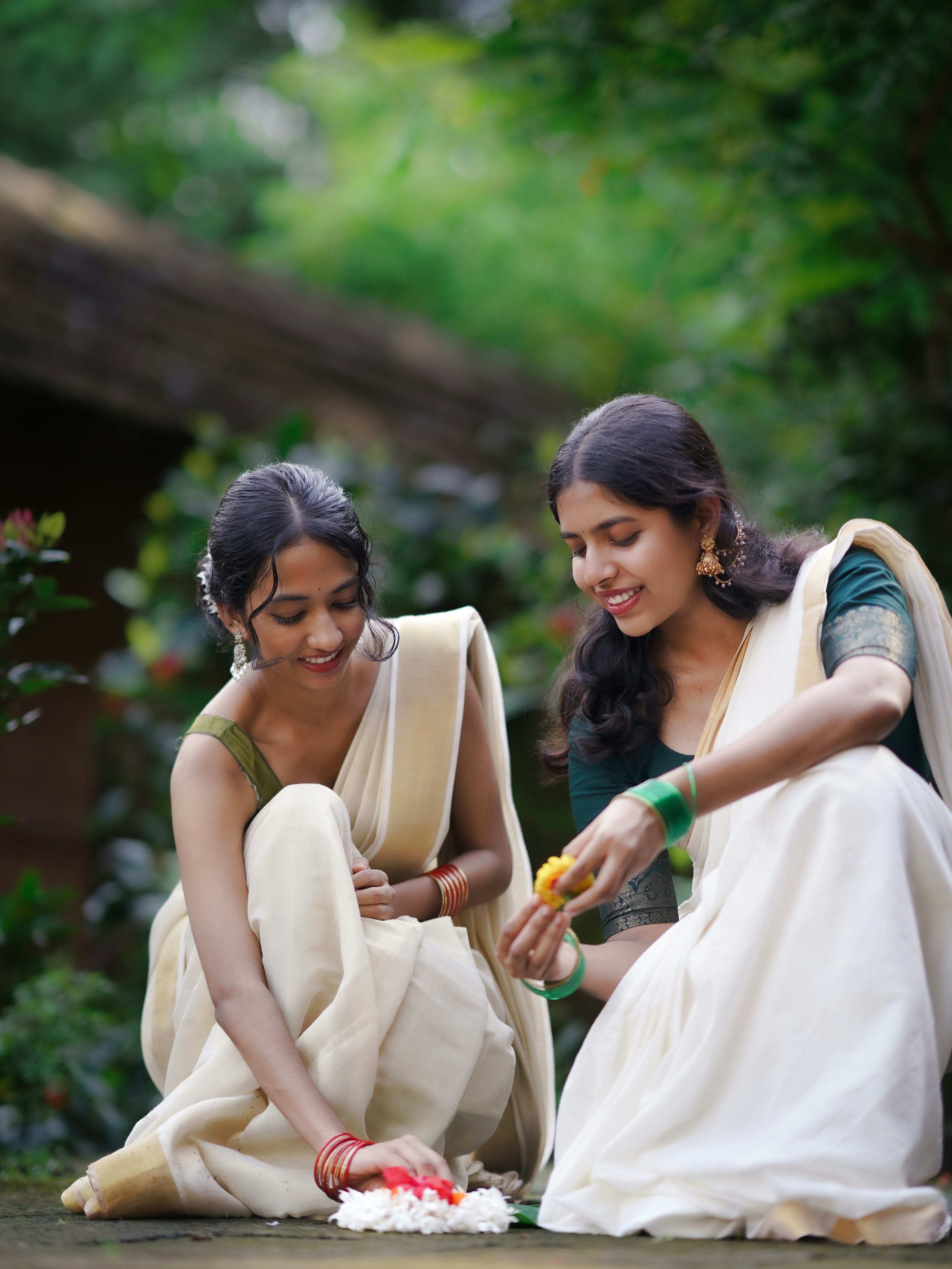 Sisters in a tranquil courtyard: petals, smiles, and soft sunlight