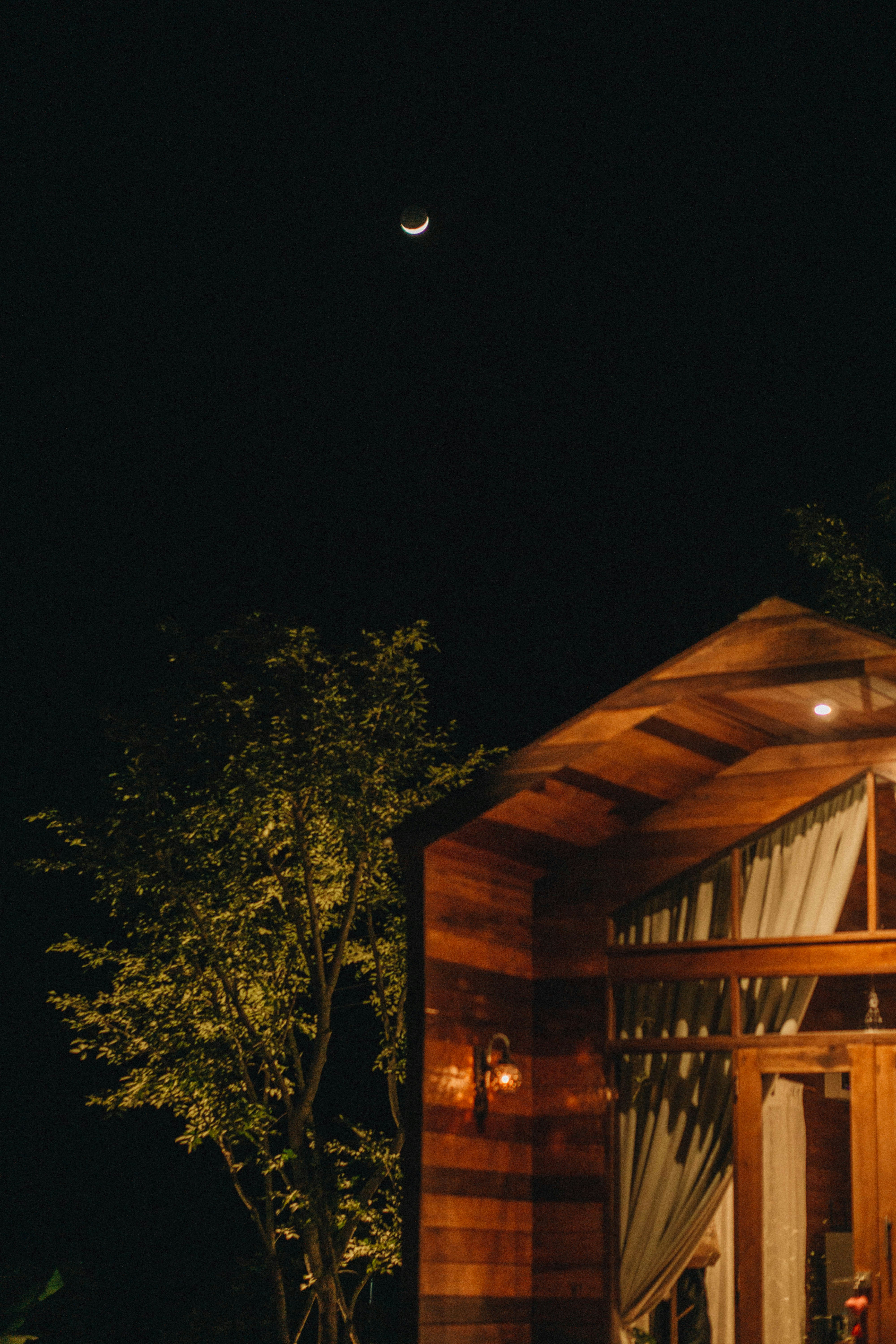 Moonlit Crescent Over a Cozy Wooden Retreat