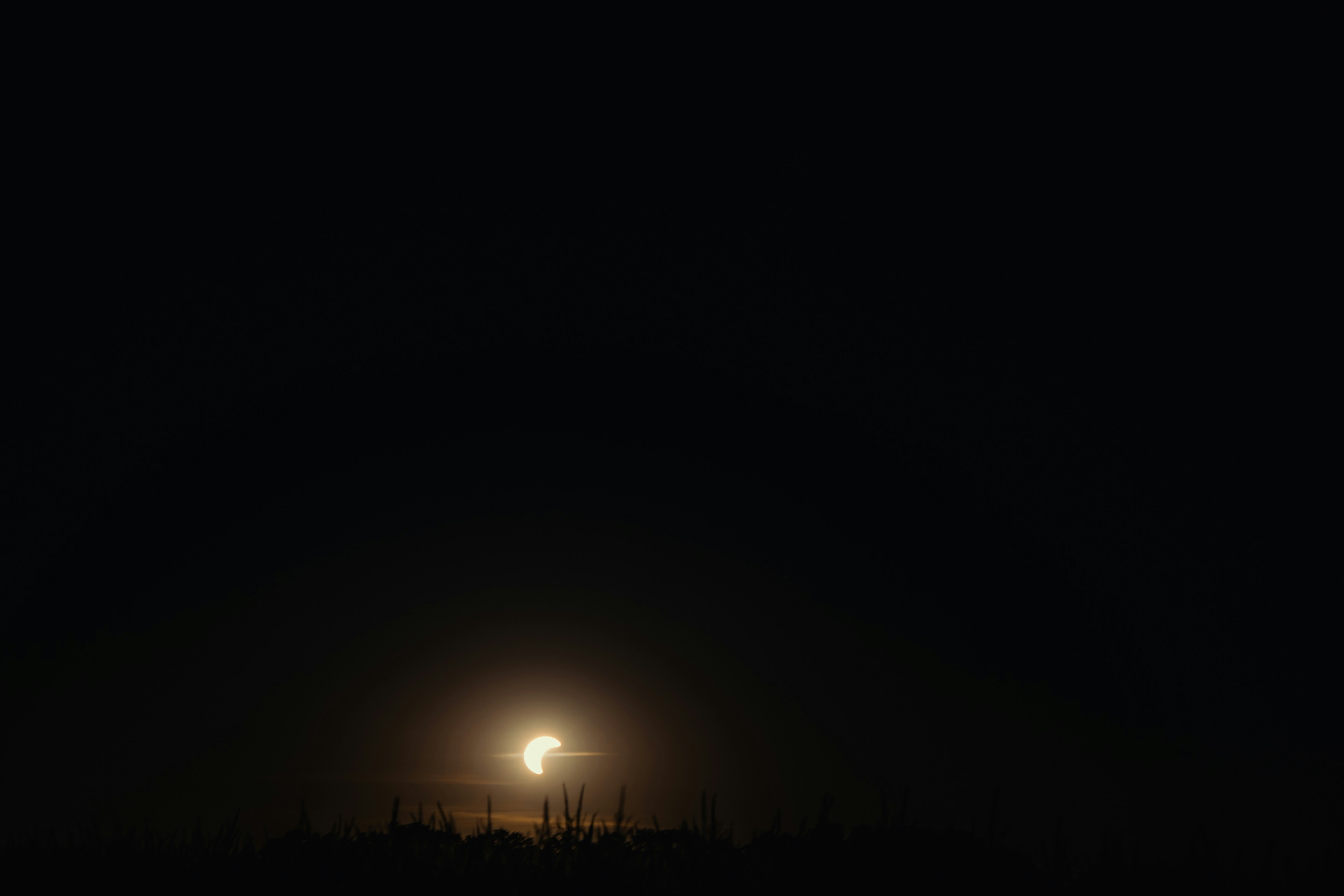 Crescent Eclipse Over Quiet Horizon