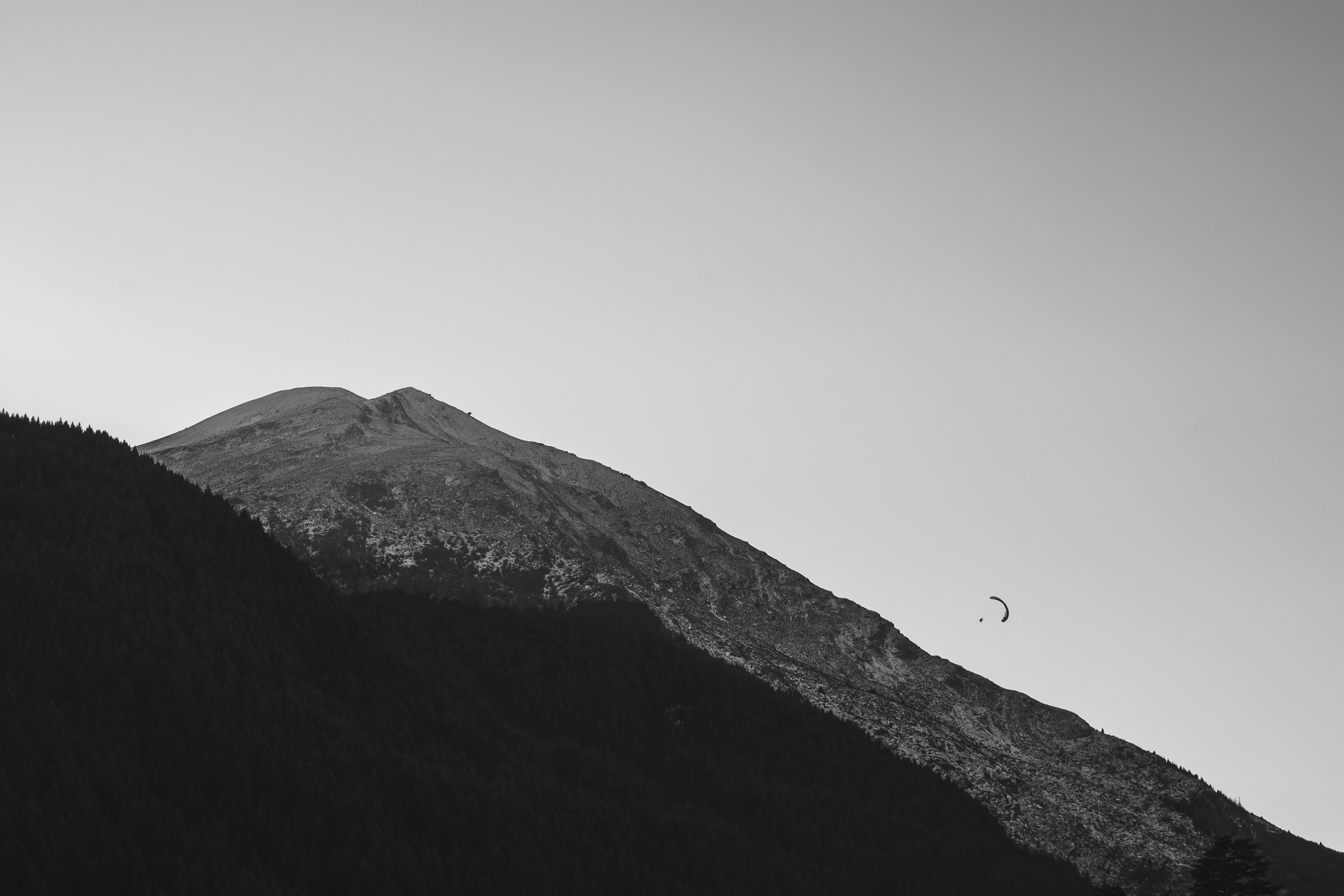 Moonlit Peak: A Lone Paraglider Skims the Ridge