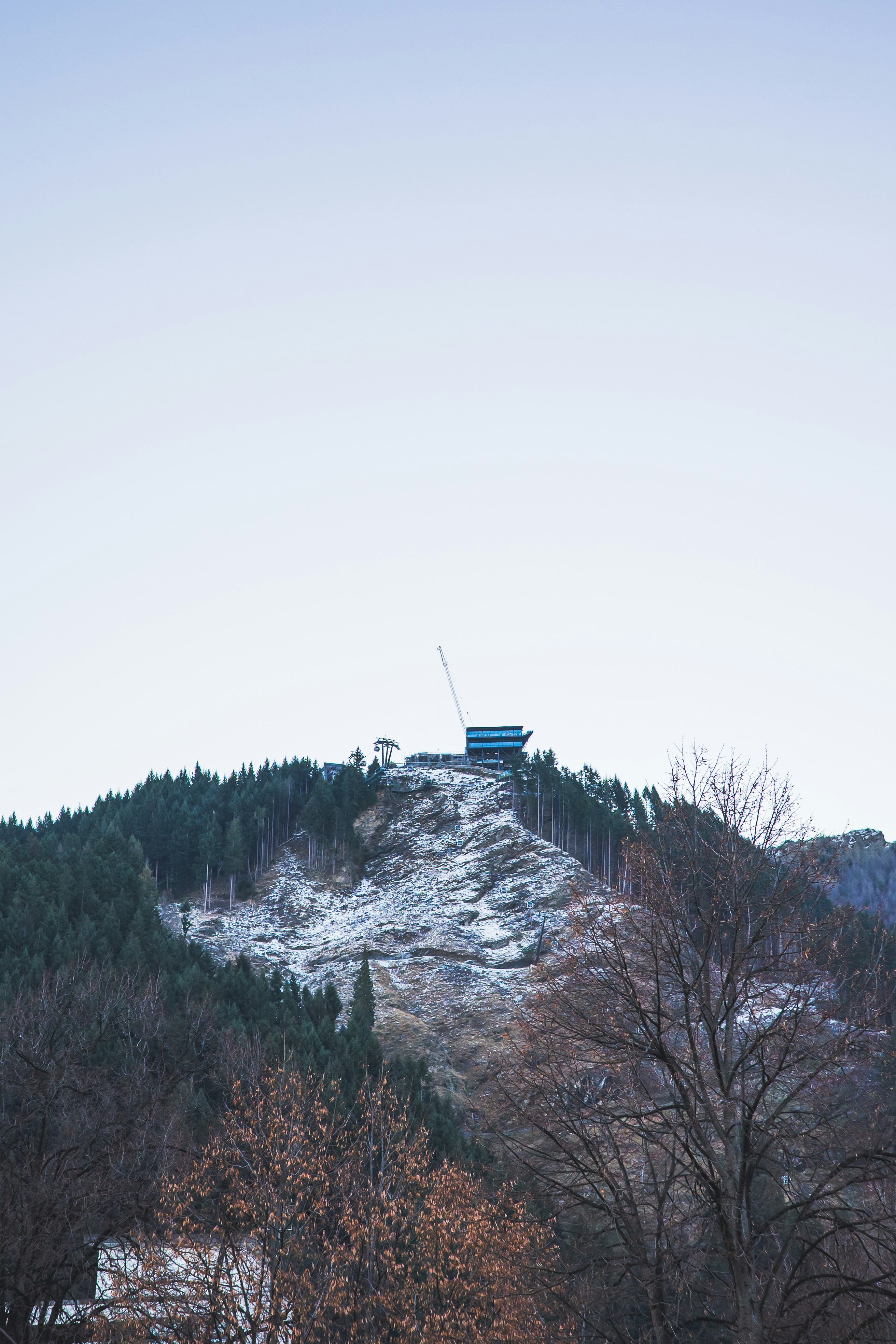 Snow-topped summit with viewing platform under a pale winter sky