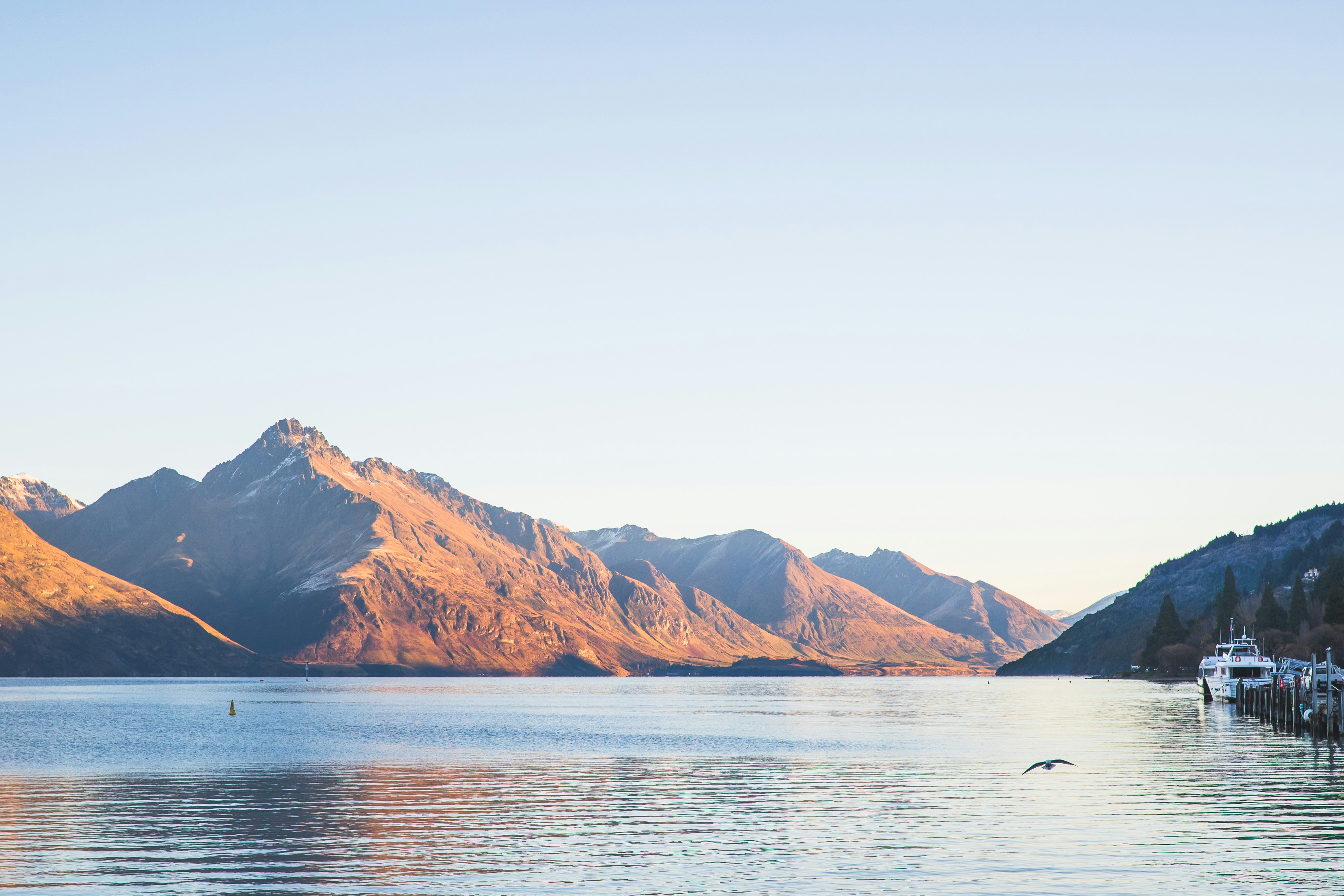 Sunlit Peaks Over a Serene Fjord